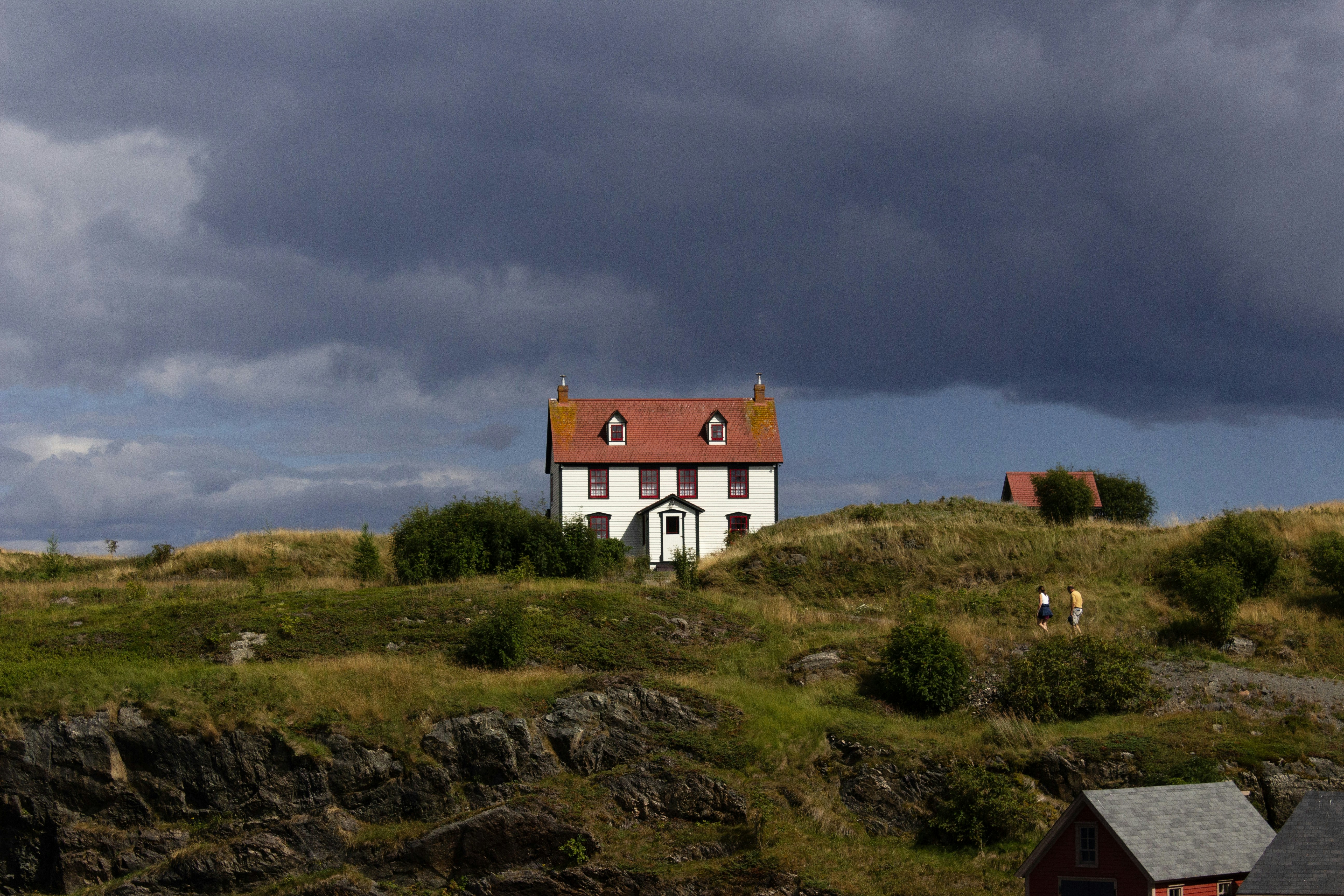Cliffside White Cottage Against a Looming Sky
