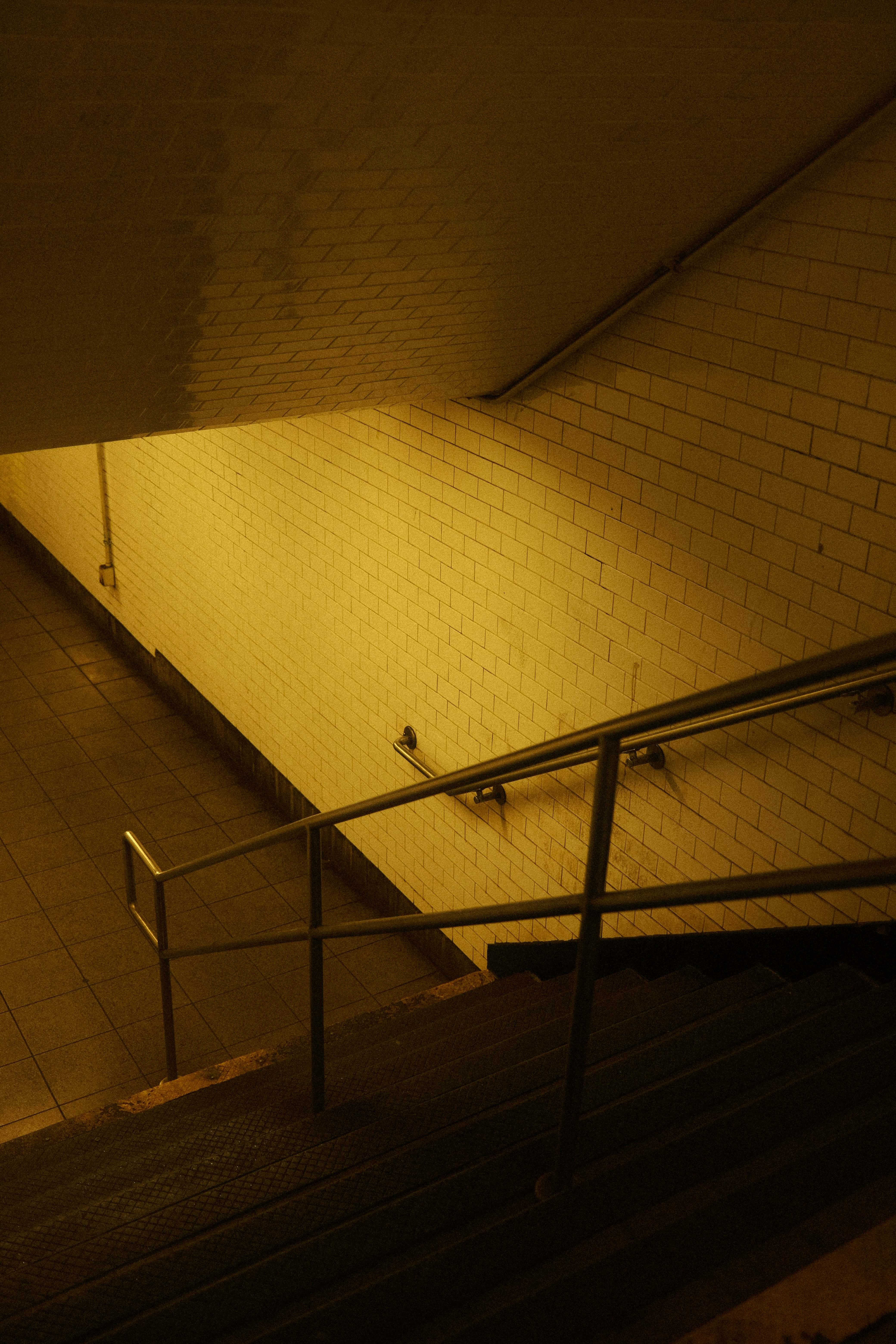 A person walking up a set of stairs at night photo – Free Street ...