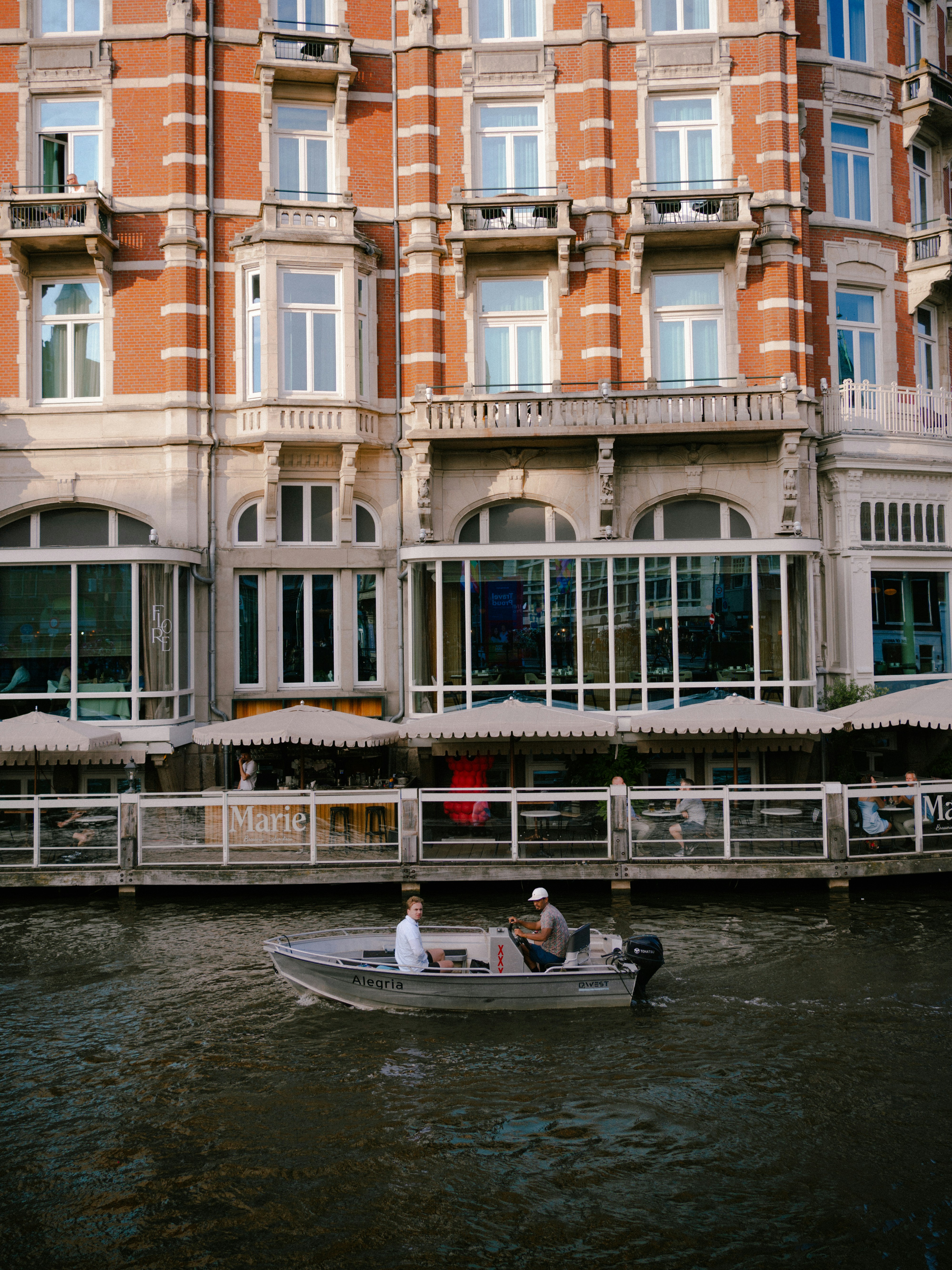 Dockside Dialogue: A Small Boat Traverses a Grand Brick Canalfront