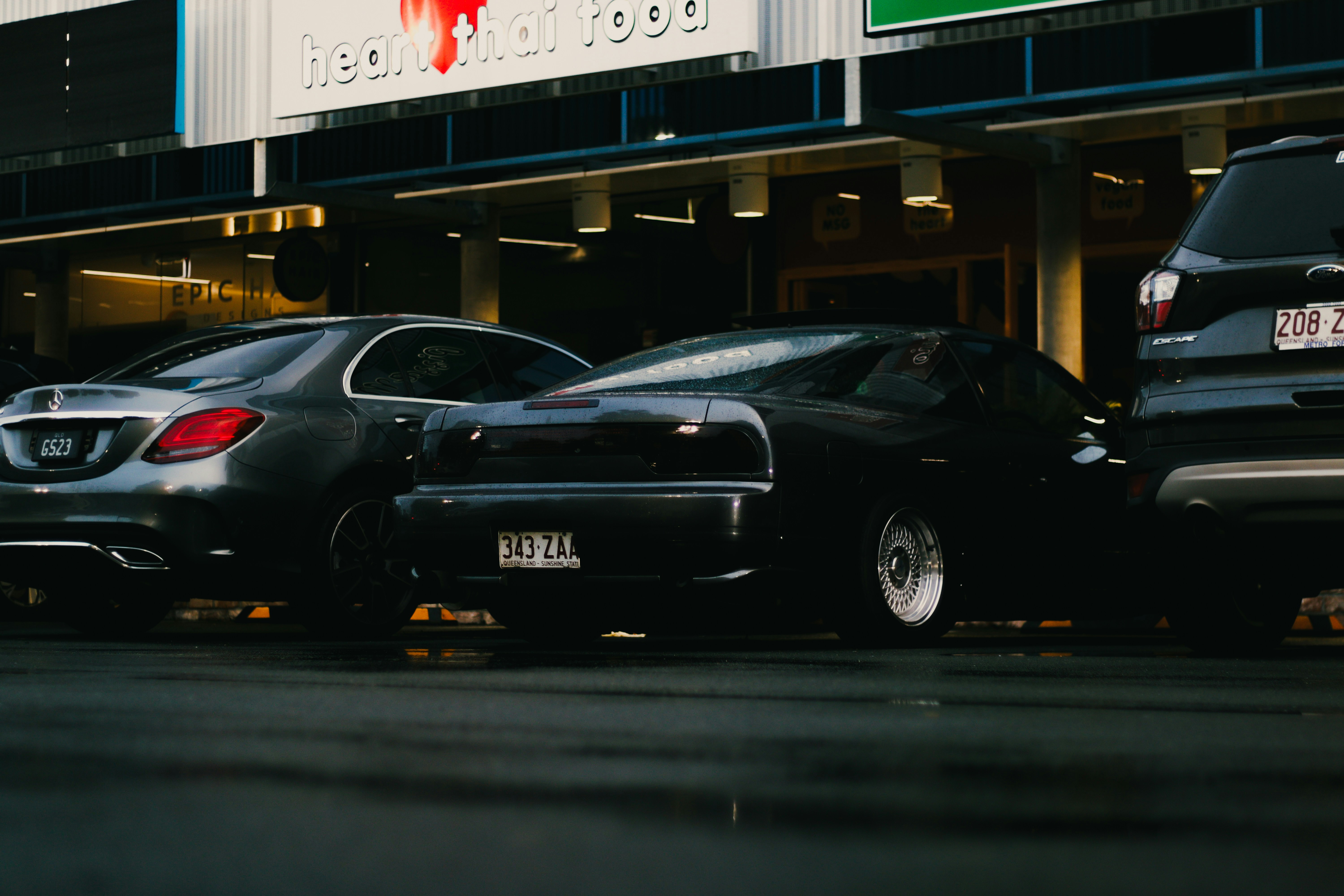 A row of parked cars in front of a building photo – Free Automobile ...