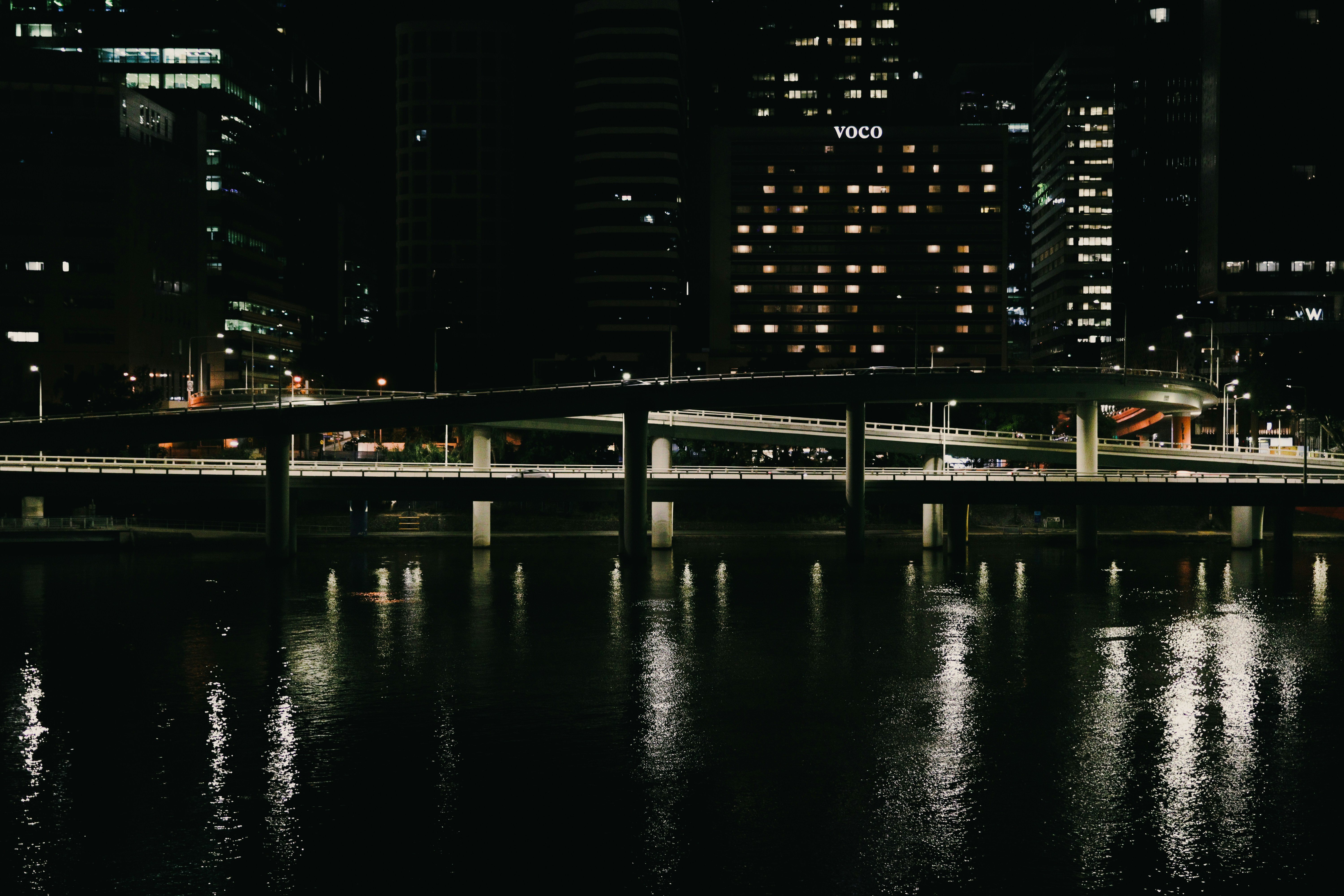 Bridge of Glass and Glow: Nocturnal Riverfront with Neon Reflections