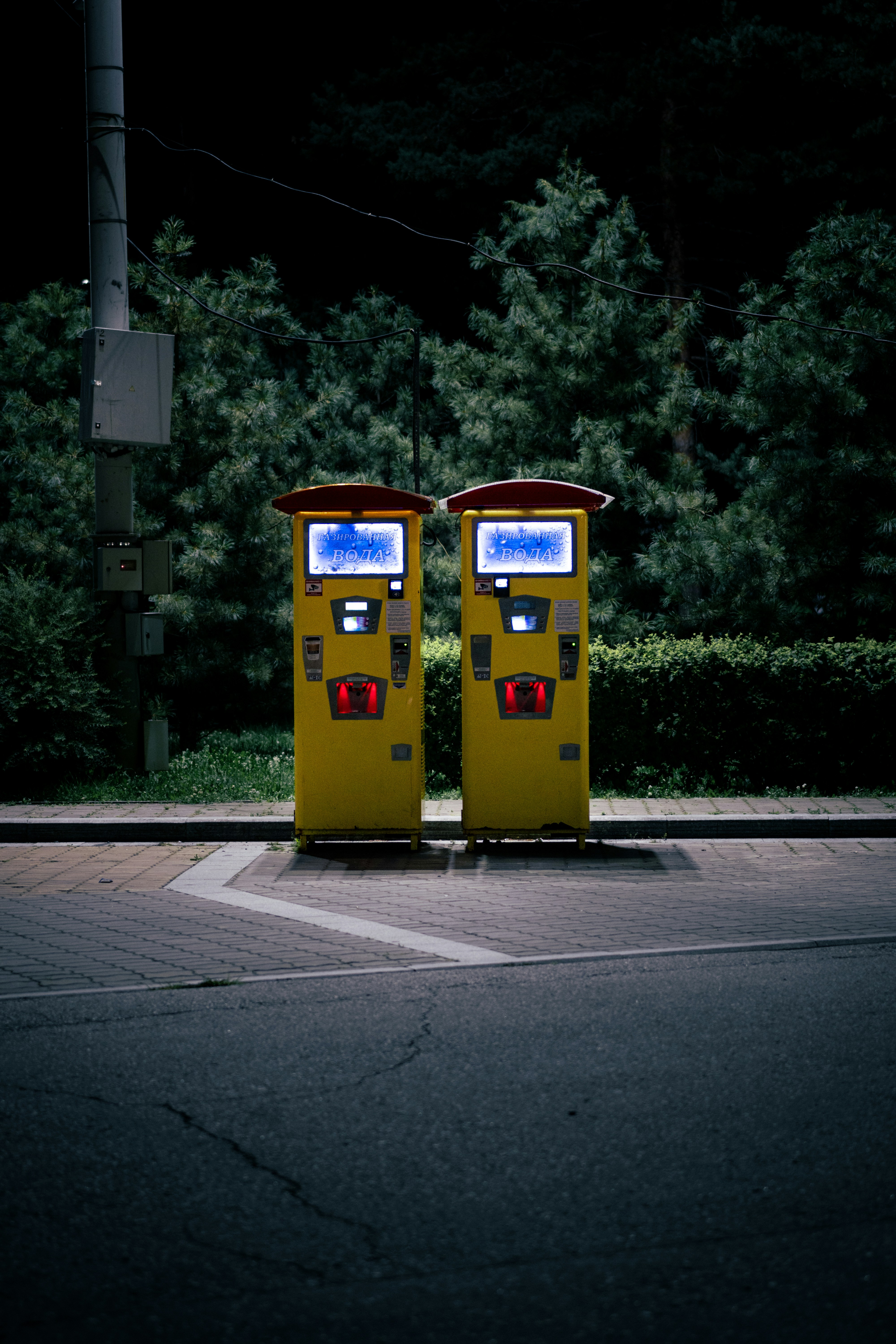 A couple of yellow machines sitting on the side of a road photo – Free ...