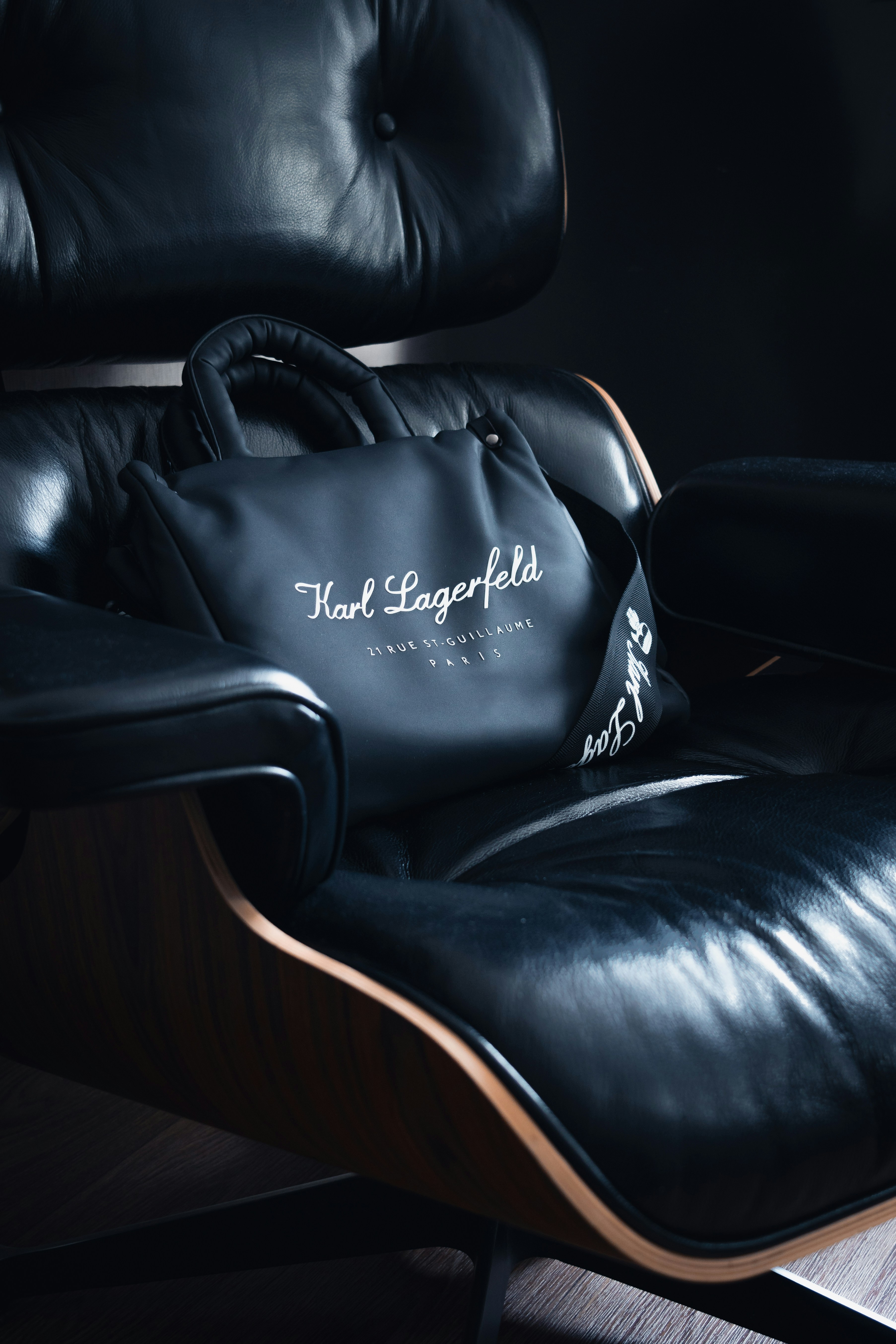 Midnight Leather, Quiet Confidence: Karl Lagerfeld Bag on a Modern Leather Lounge Chair