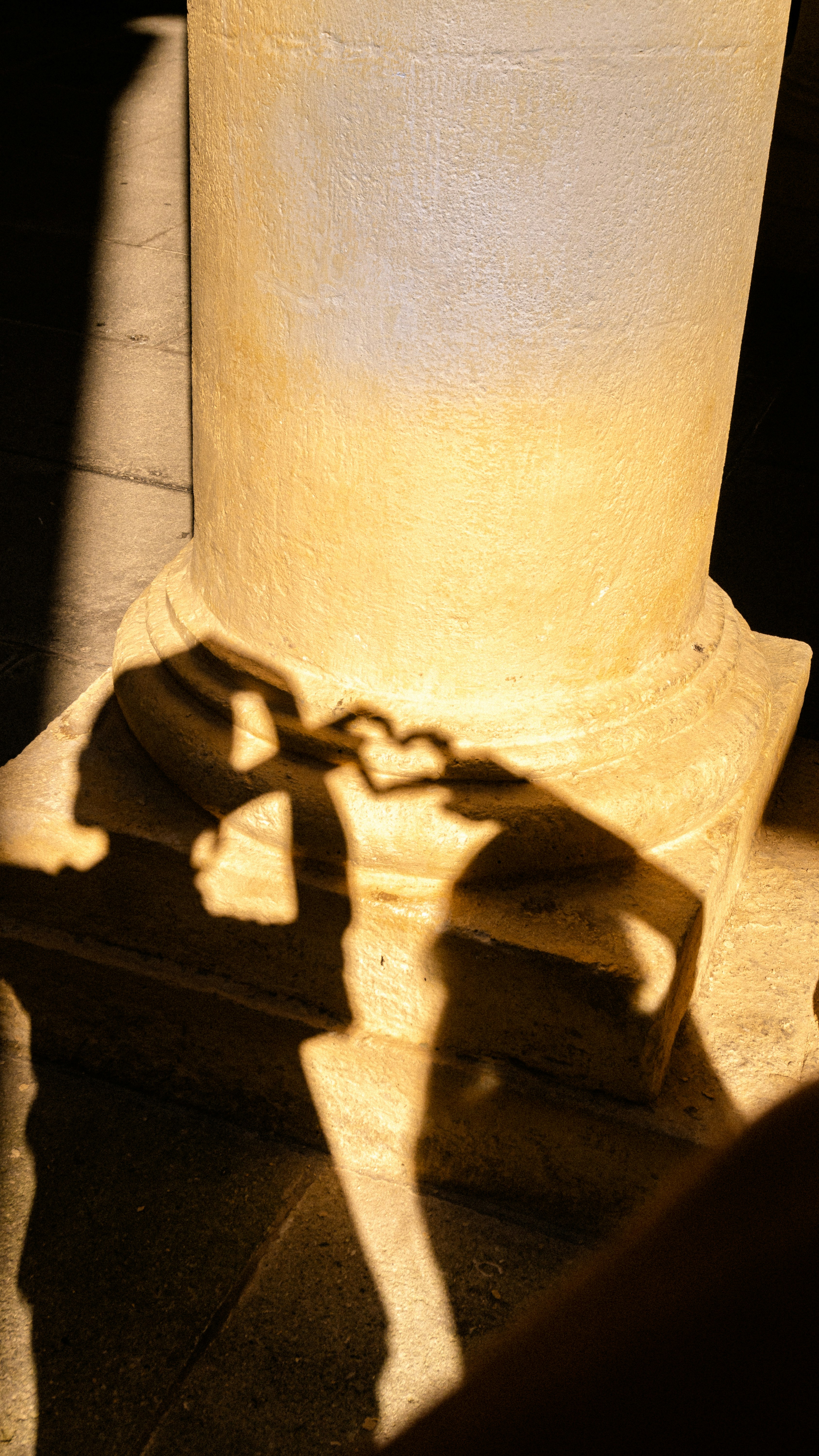 Amber Glow on a Stone Column: Shadow Play at the Base