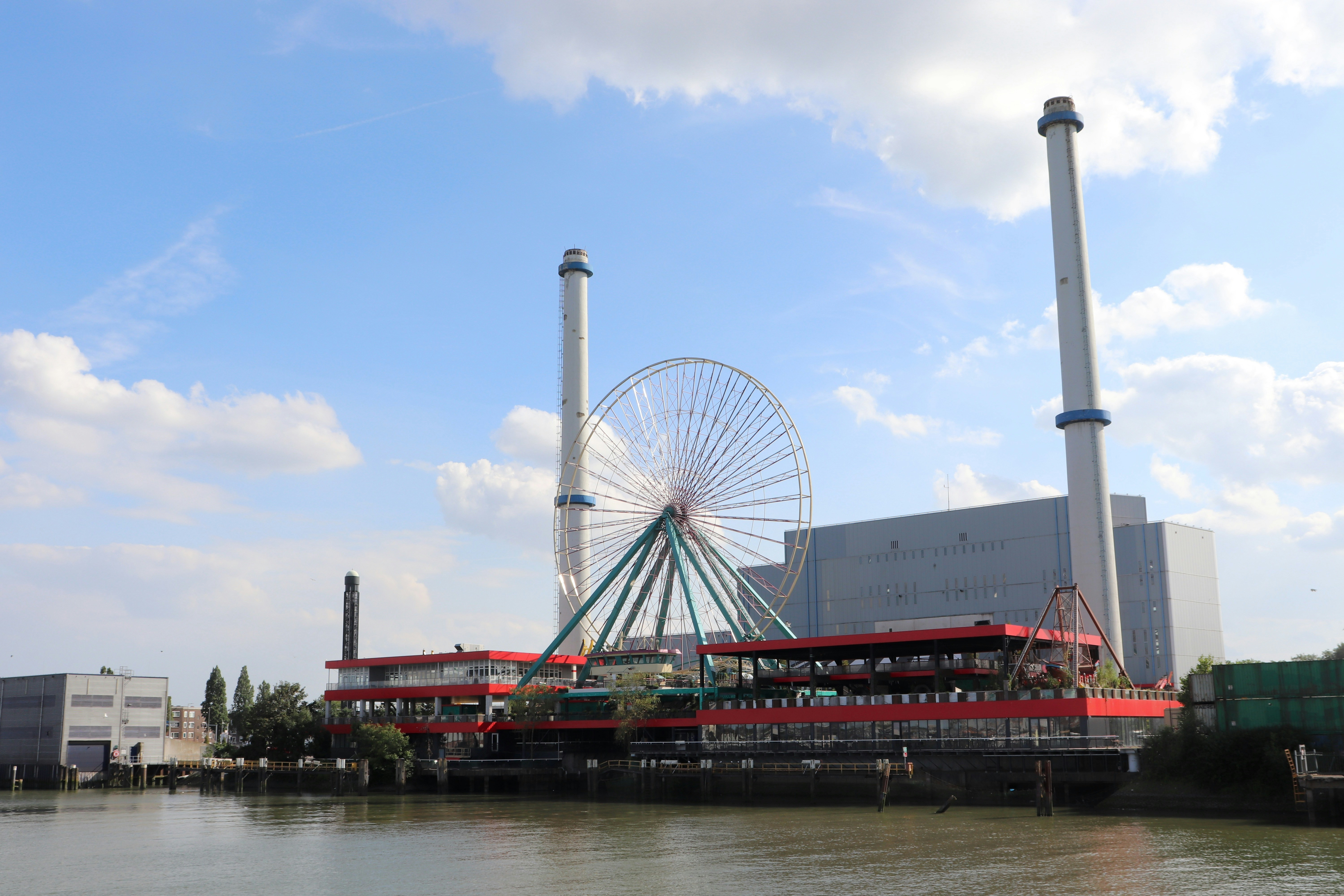 Ferris Wheel Anchored by Twin Towers Along a Riverfront Pier