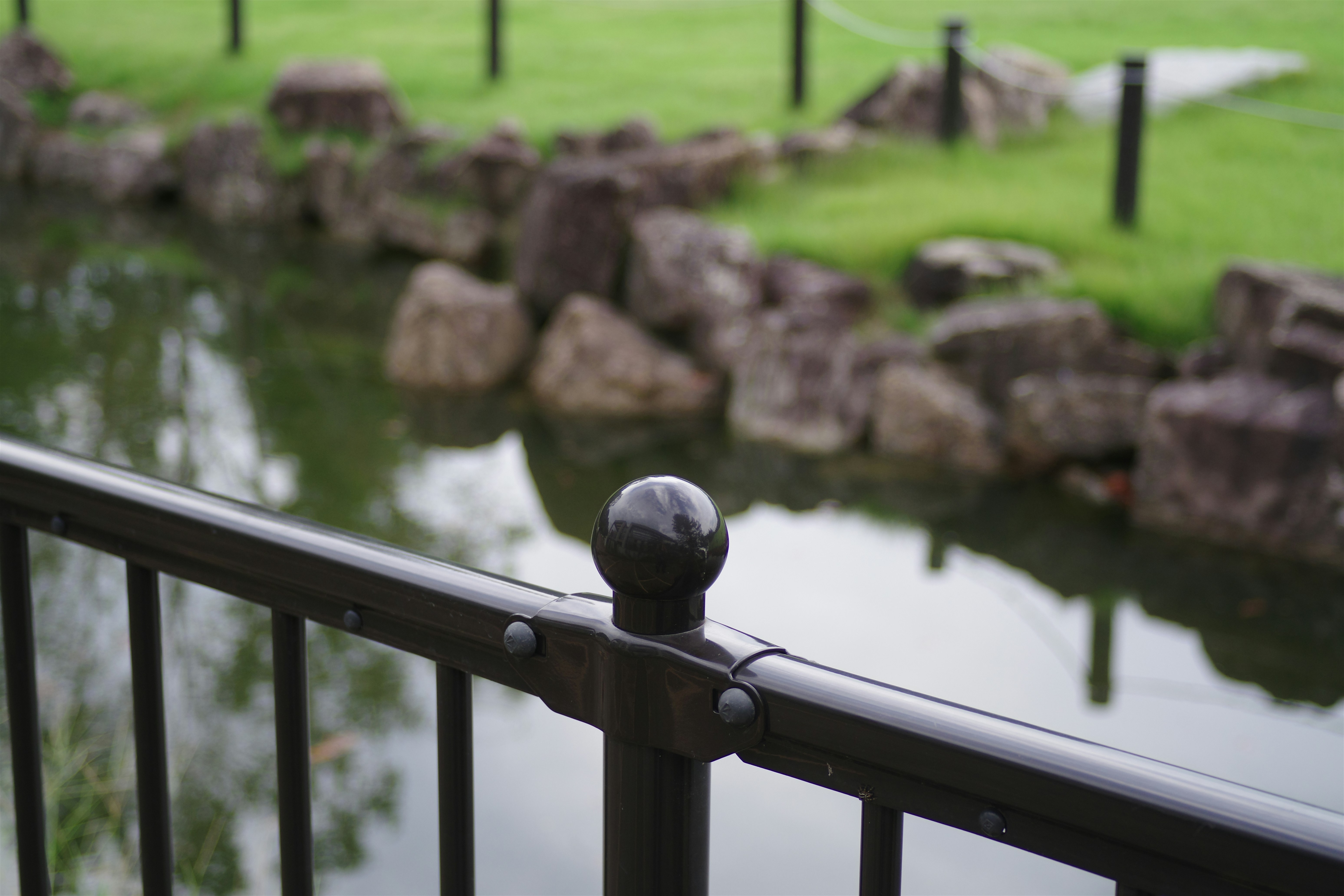 Sphere atop the railing: a quiet lakeside moment