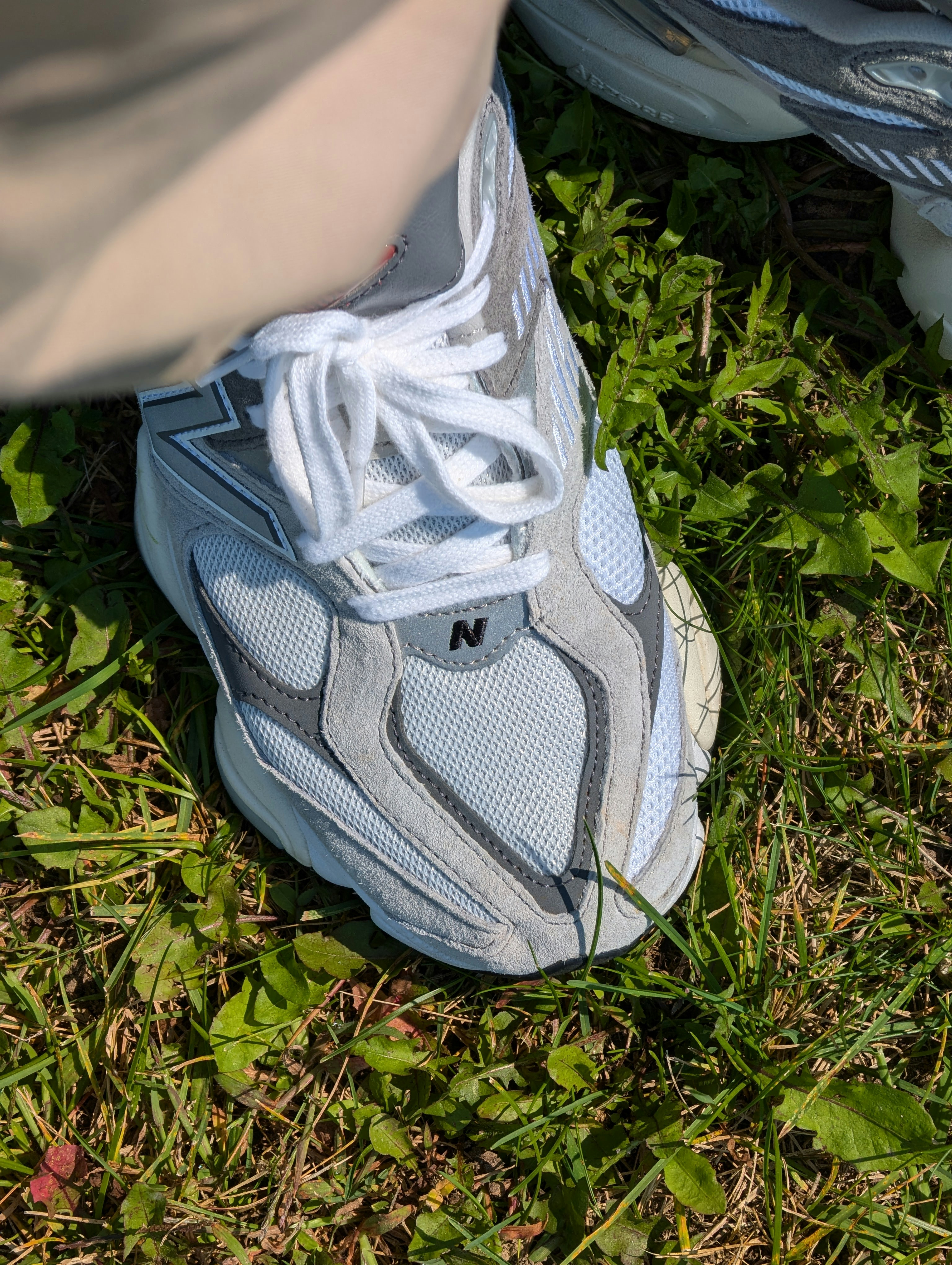 Close-Up of a New Balance Sneaker Resting on Sunlit Grass