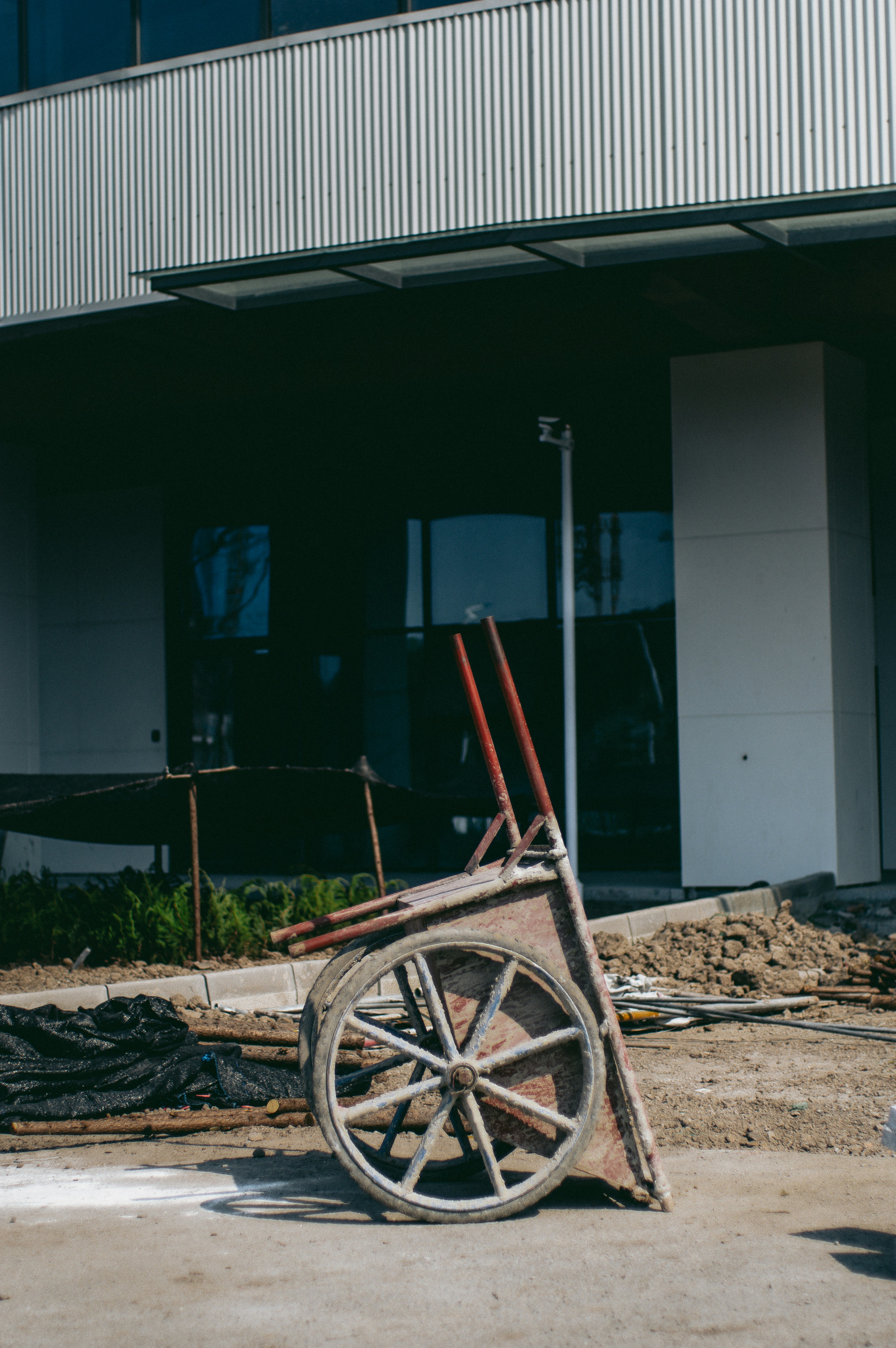 A wheelbarrow sitting in front of a building under construction photo ...