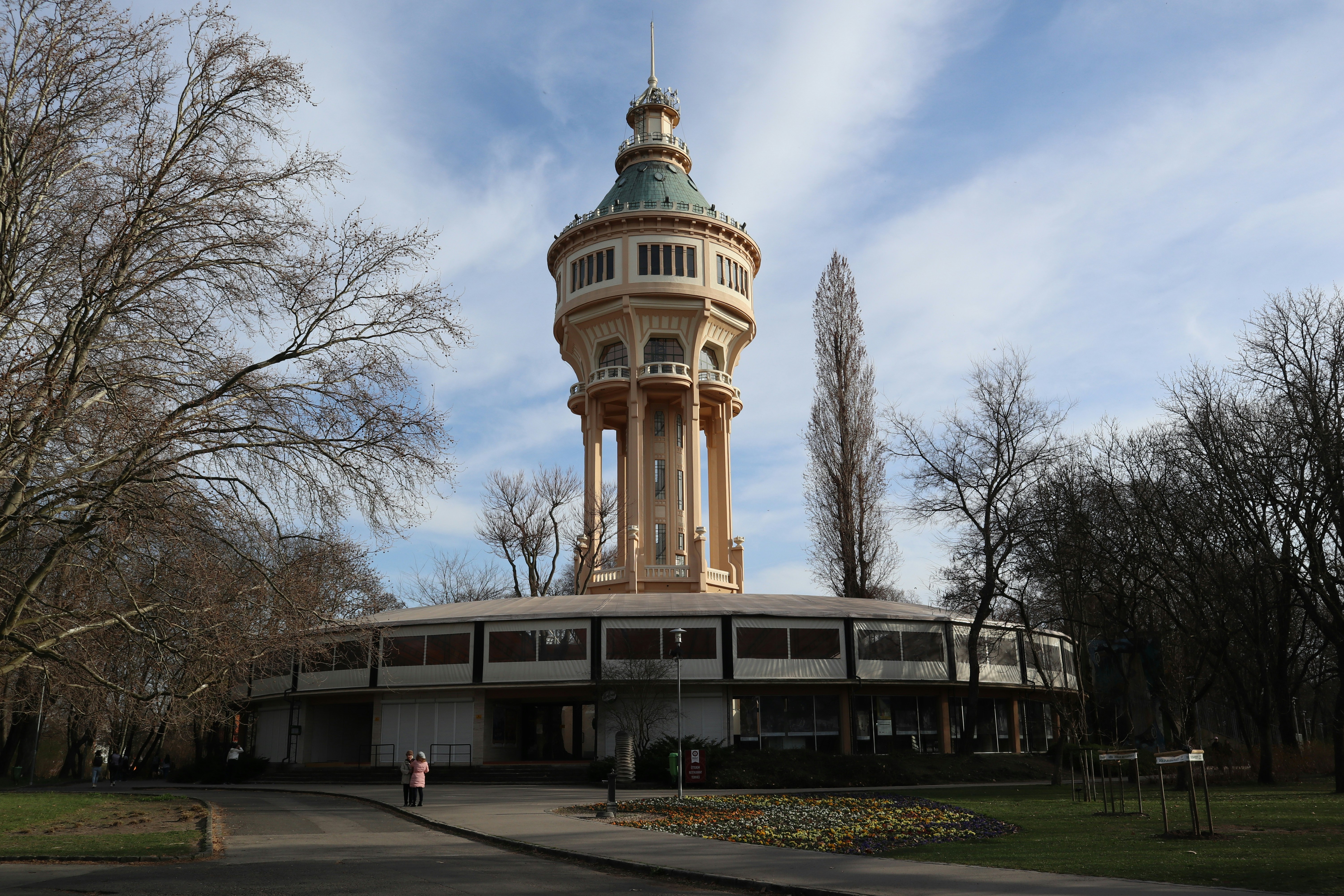 A large building with a tower in the middle of a park