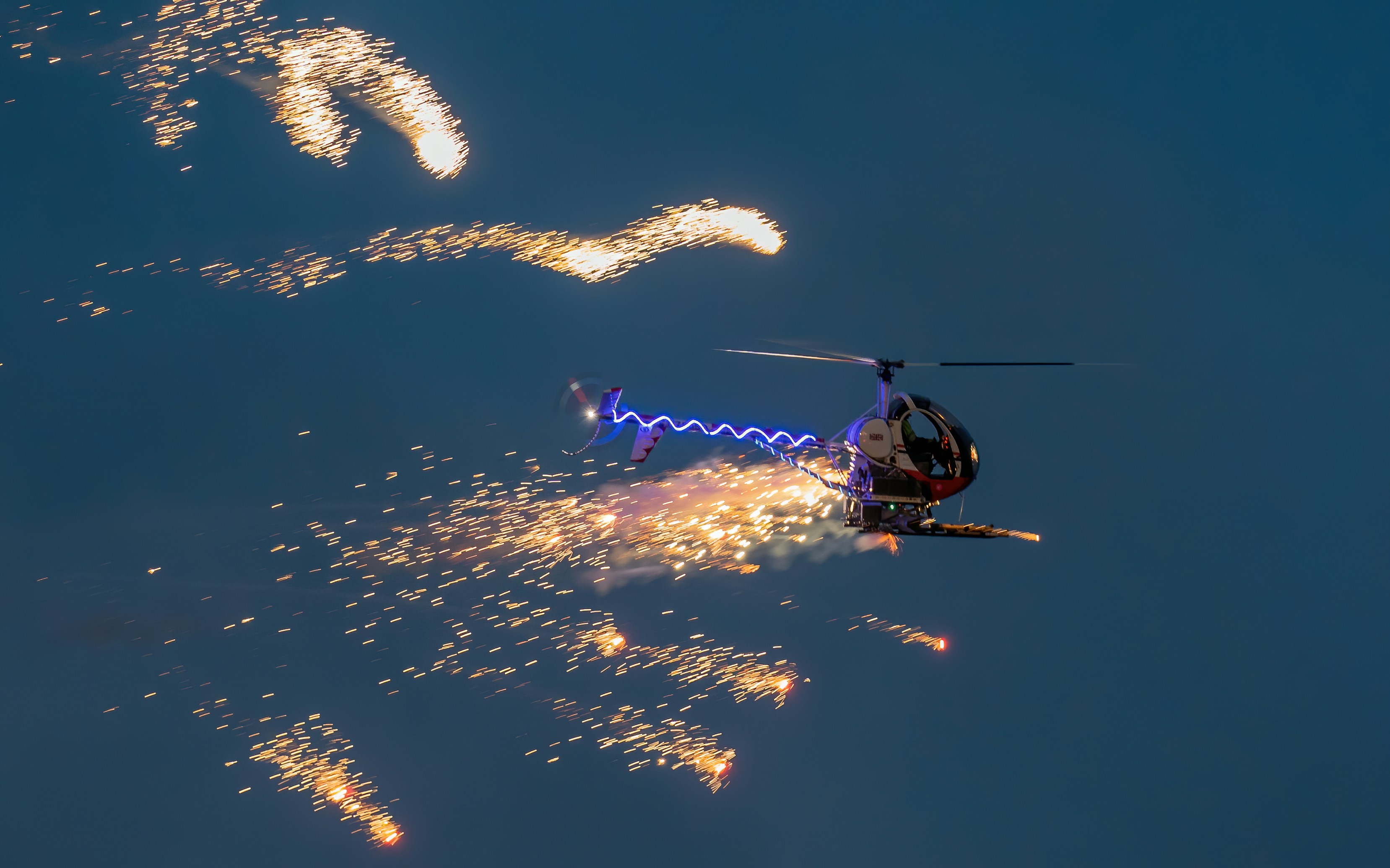 A helicopter flying through the air with fireworks coming out of it ...