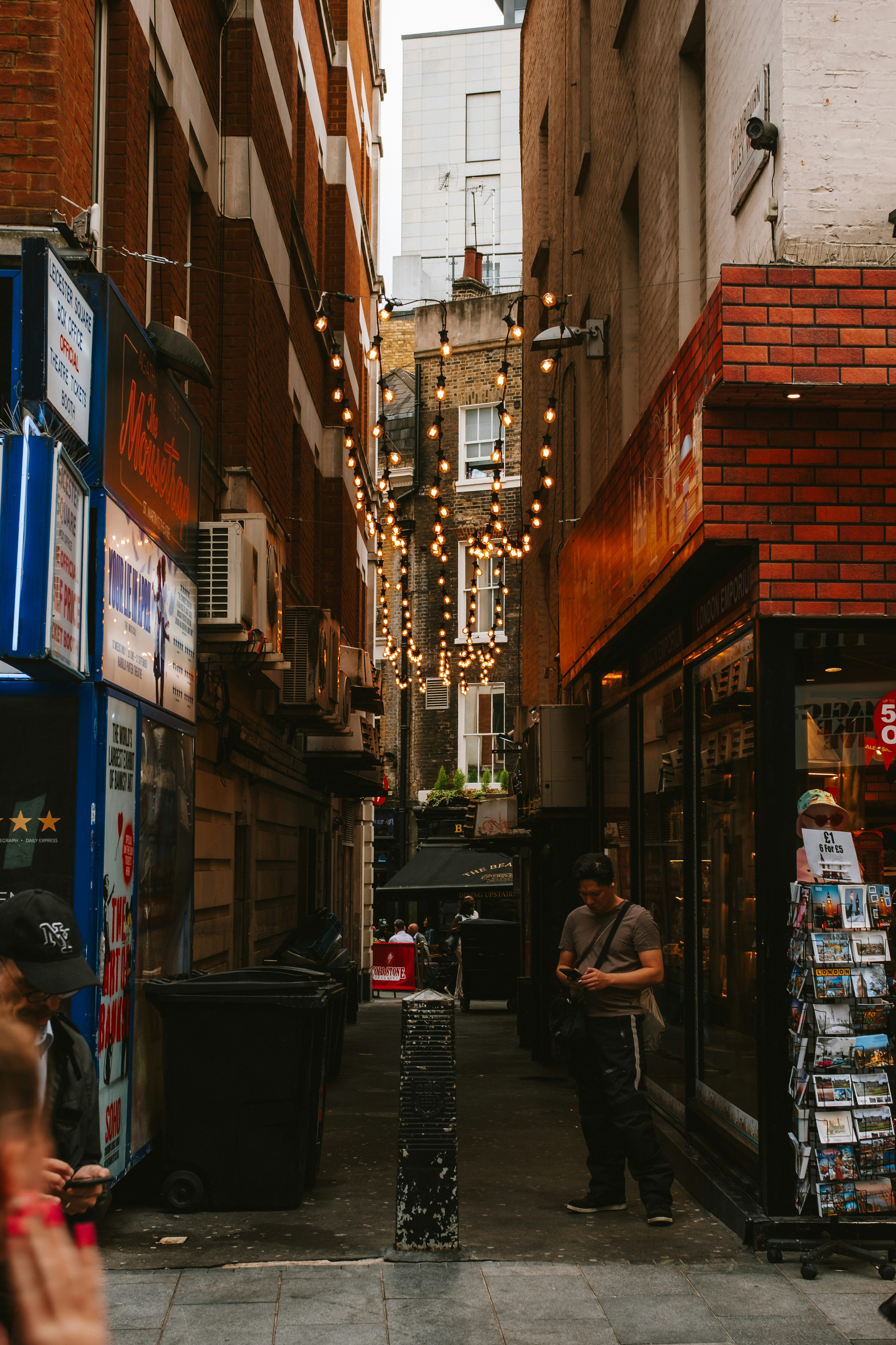 A couple of people walking down a street next to tall buildings