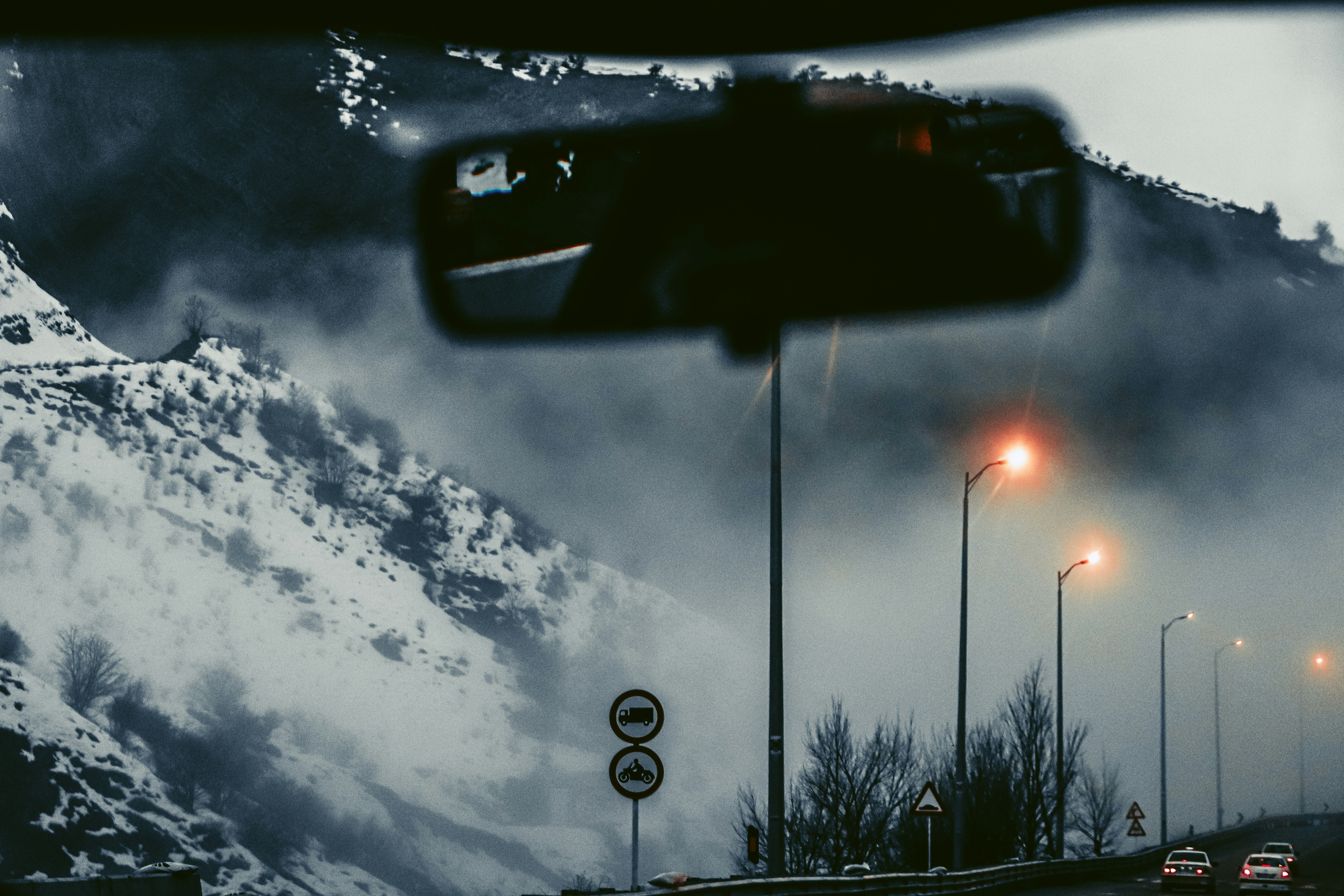 Amber Veil over a Snowbound Mountain Road in Mist