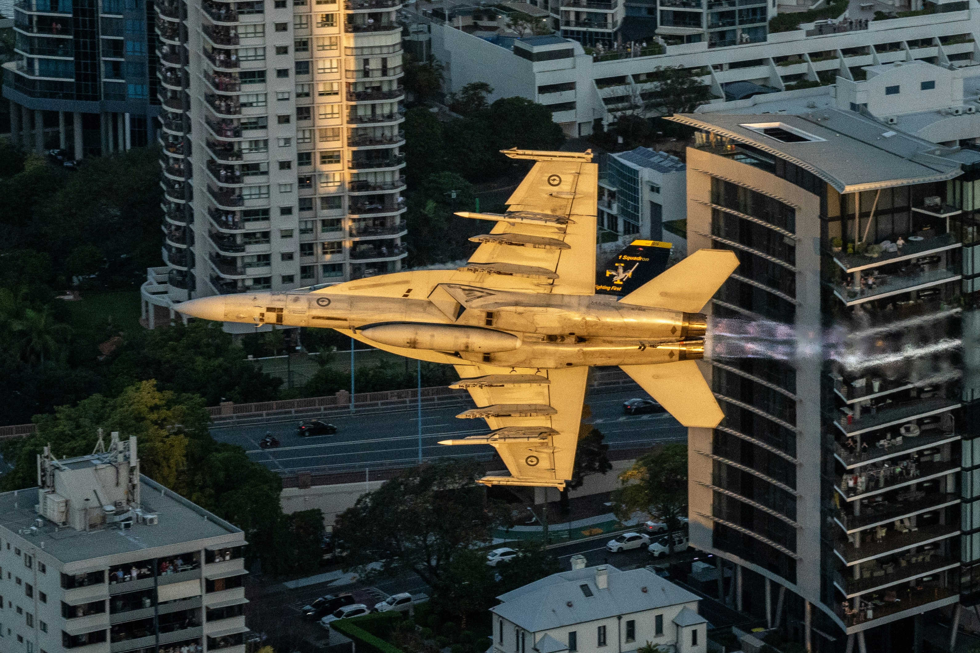 A fighter jet flying over a city with tall buildings photo – Free ...