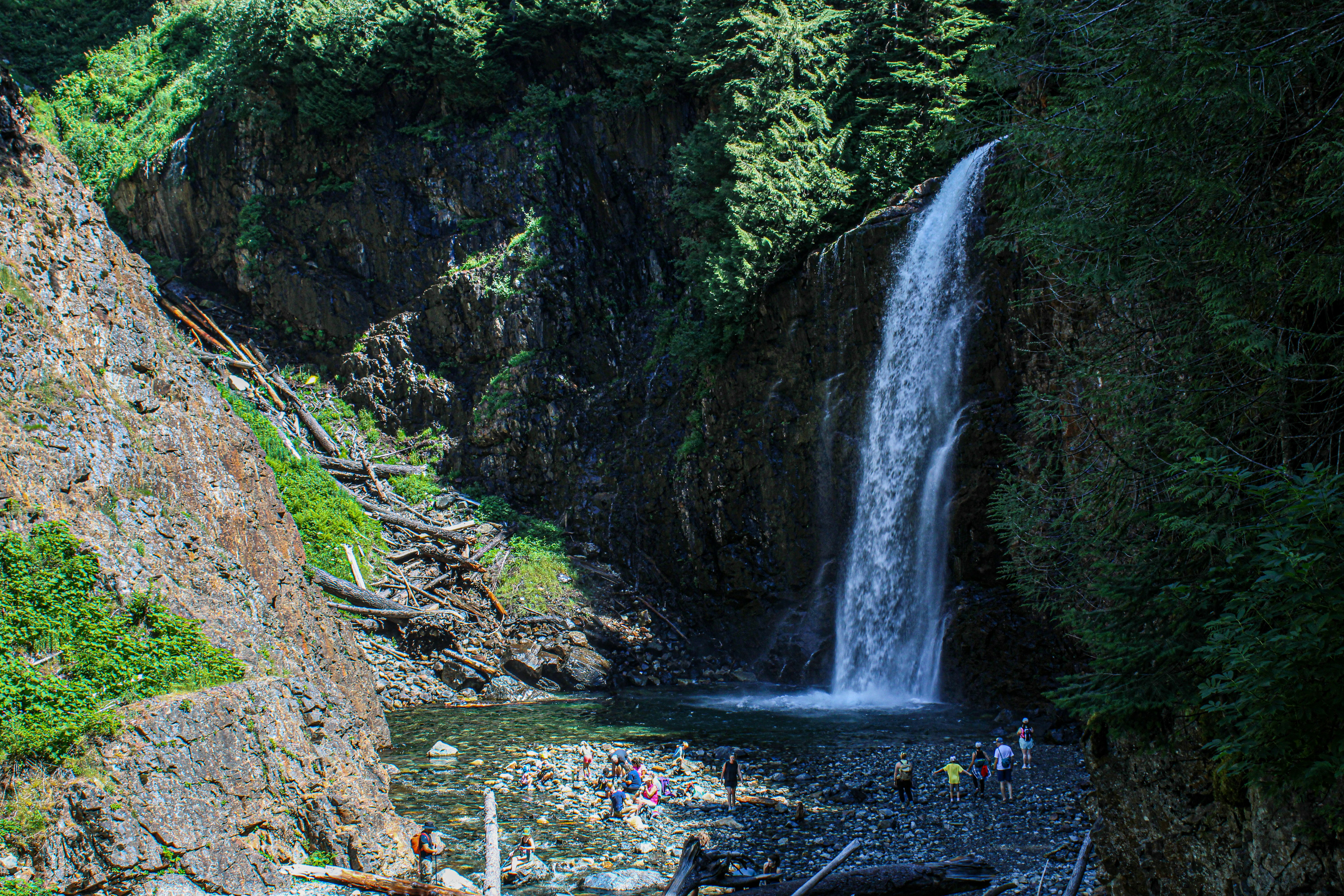 A group of people standing in front of a waterfall photo – Free ...
