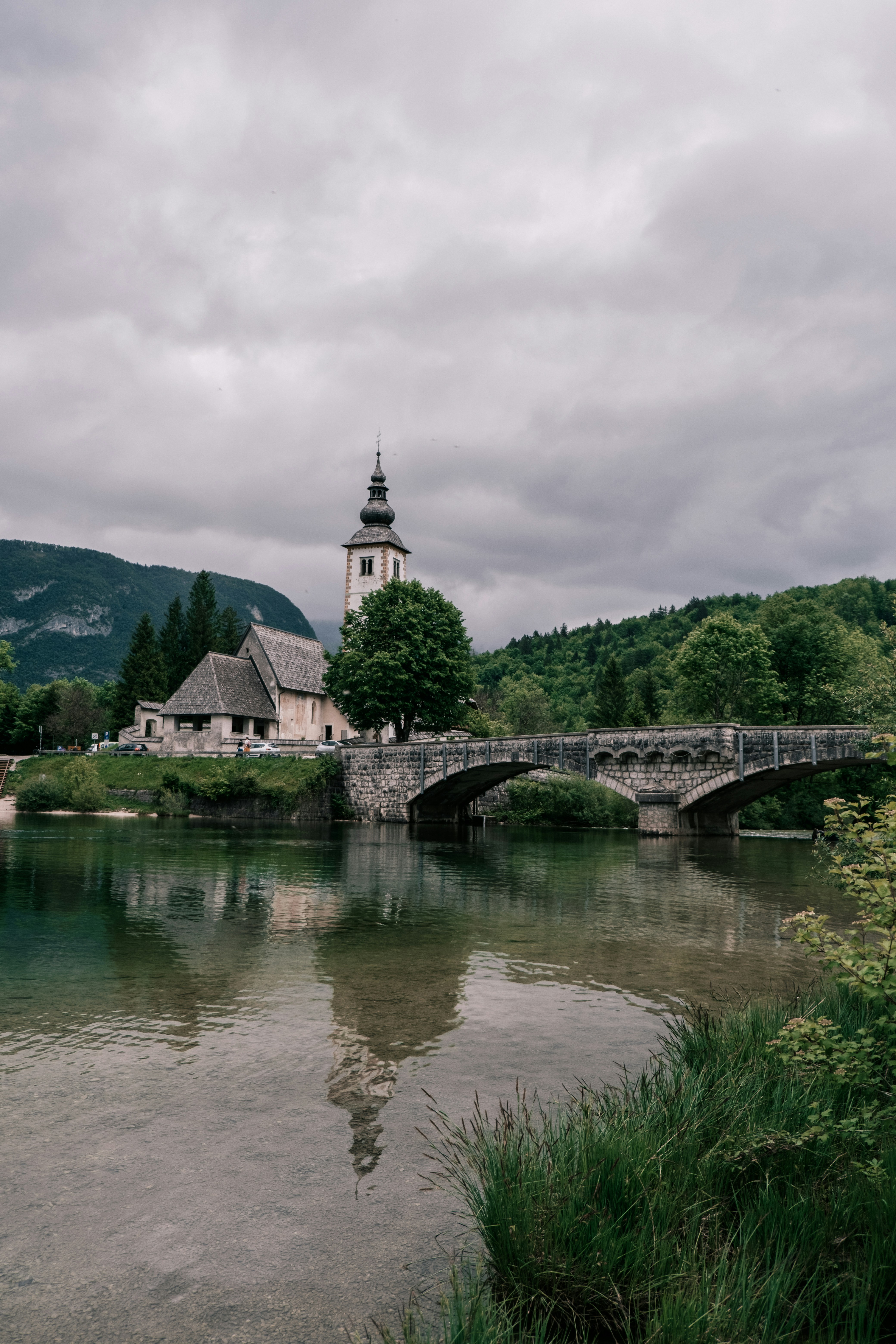 A bridge over a river with a church in the background