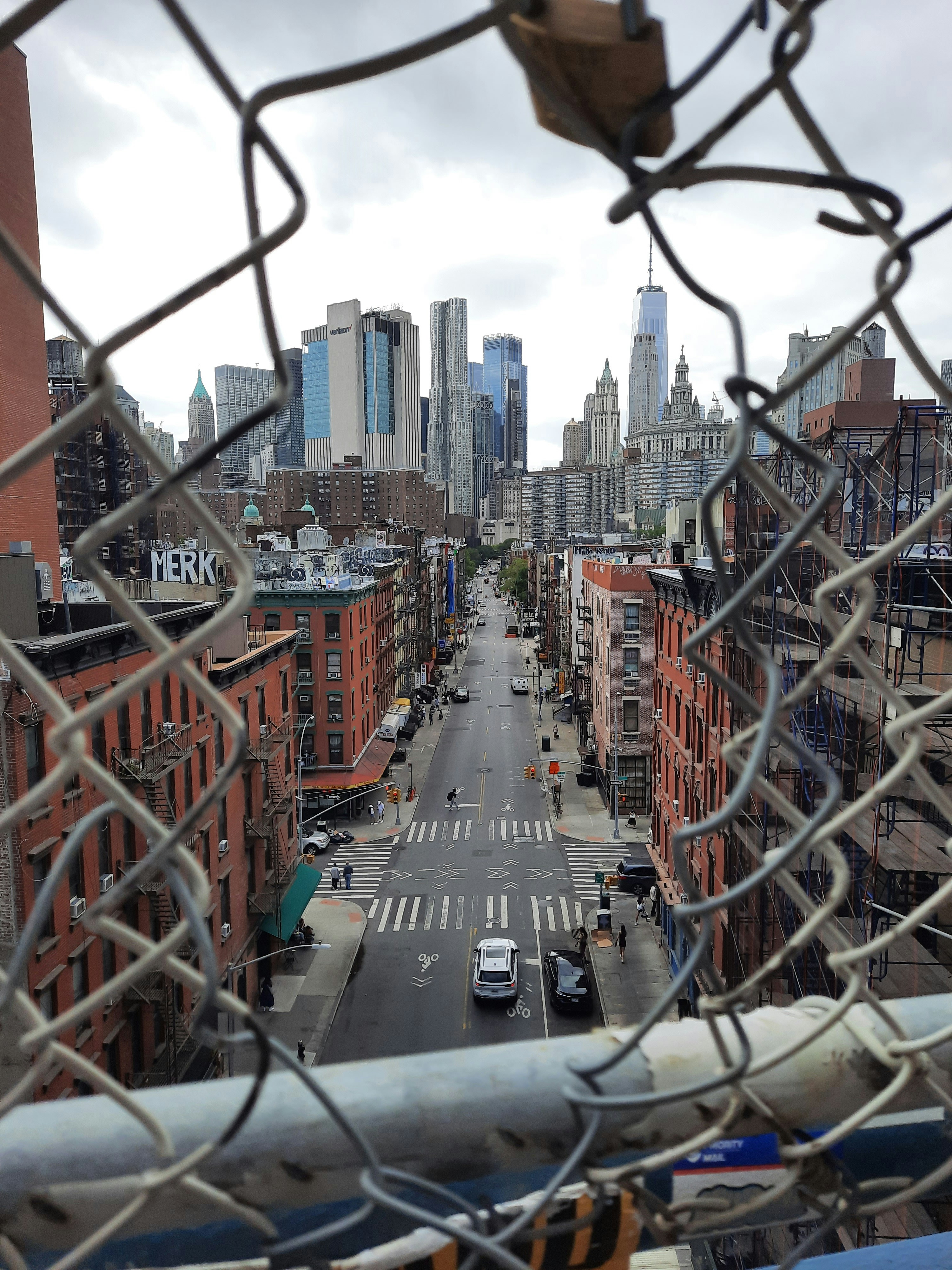 Chain-Link Corridor to a Concrete Canopy: A Street Canyon Framing the Skyline