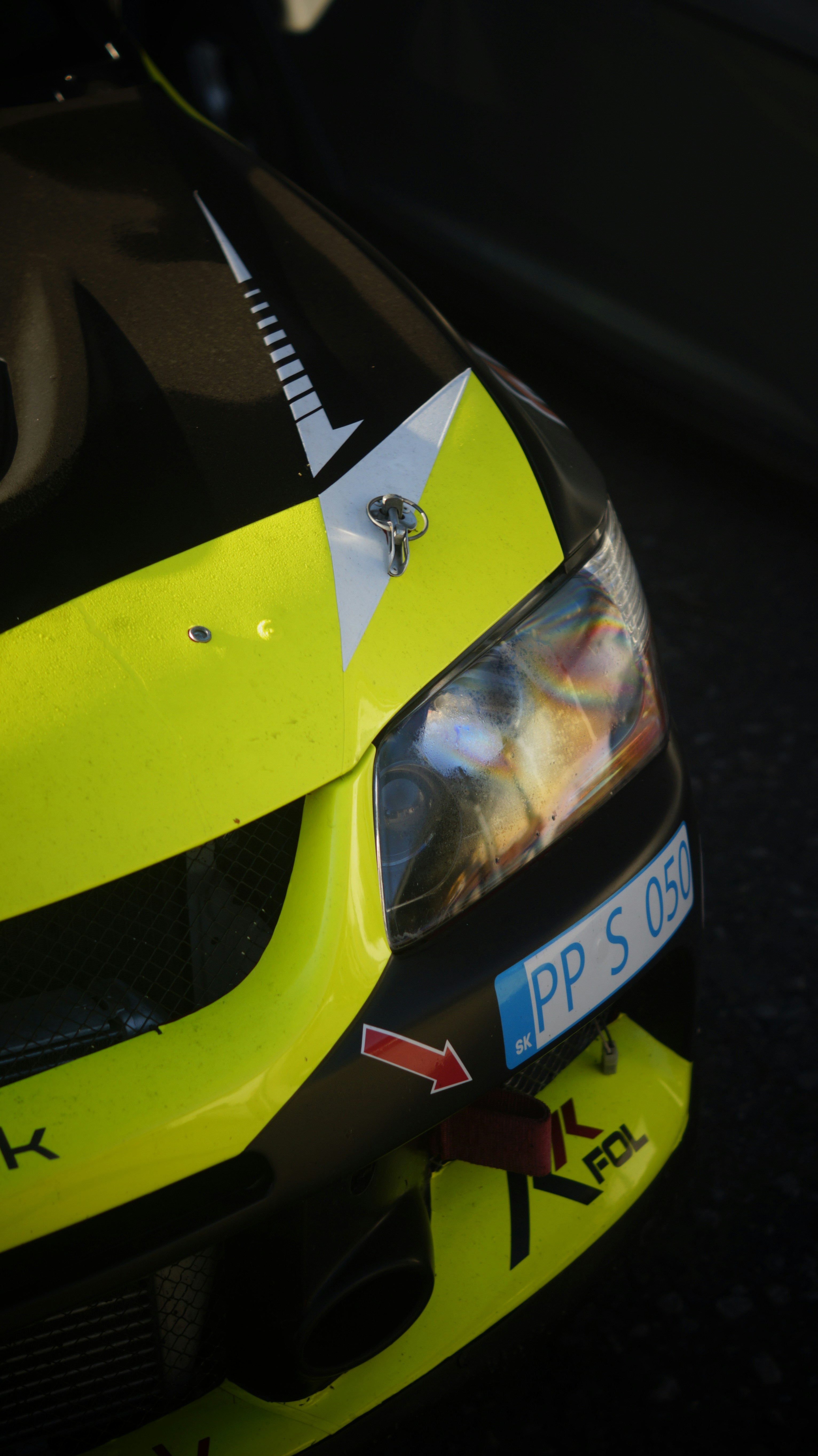Key on Neon Rally Hood: Chrome Accent resting on lime-yellow racecar front