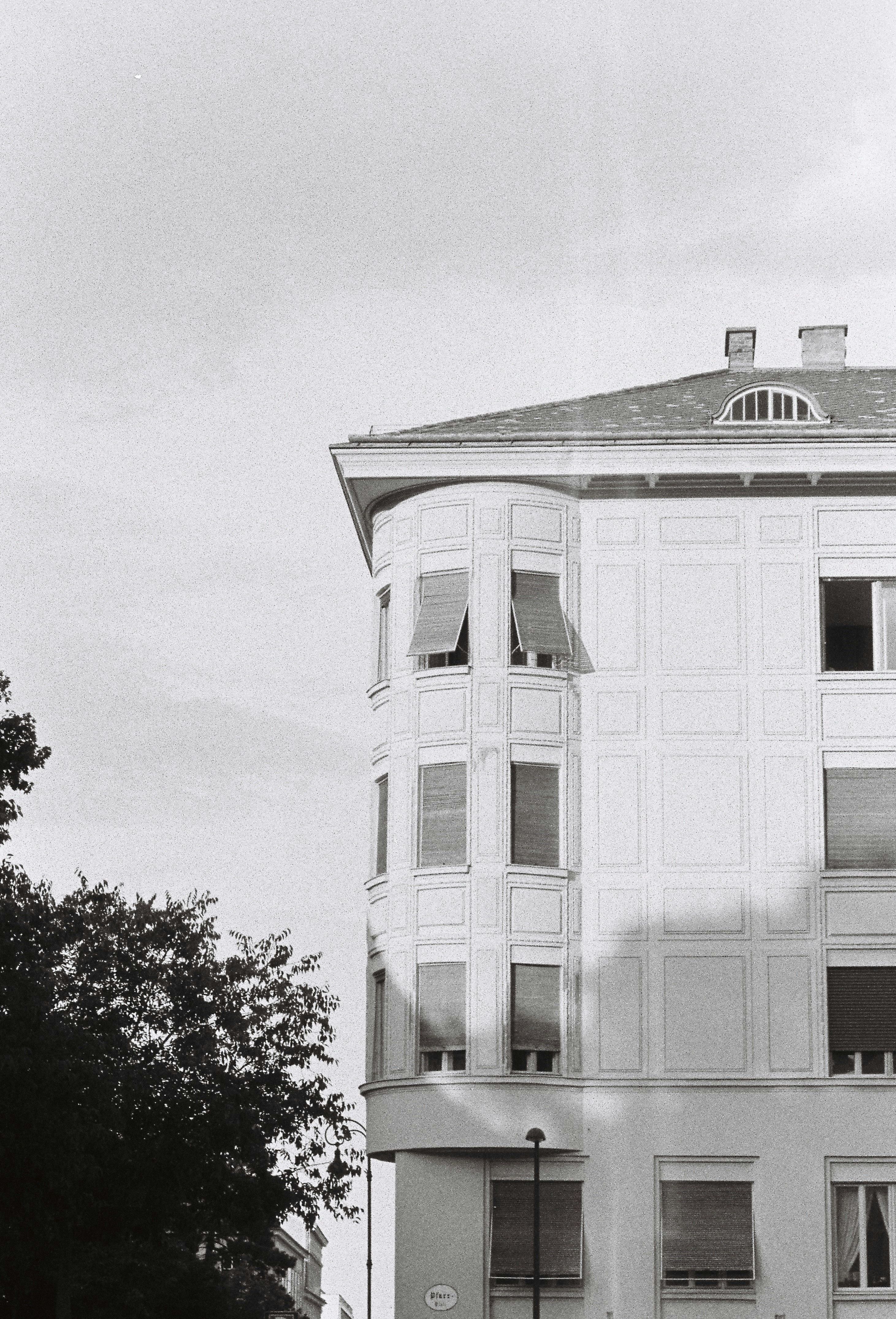 Una foto en blanco y negro de un edificio alto foto – Imagen de Película gratuita en Unsplash
