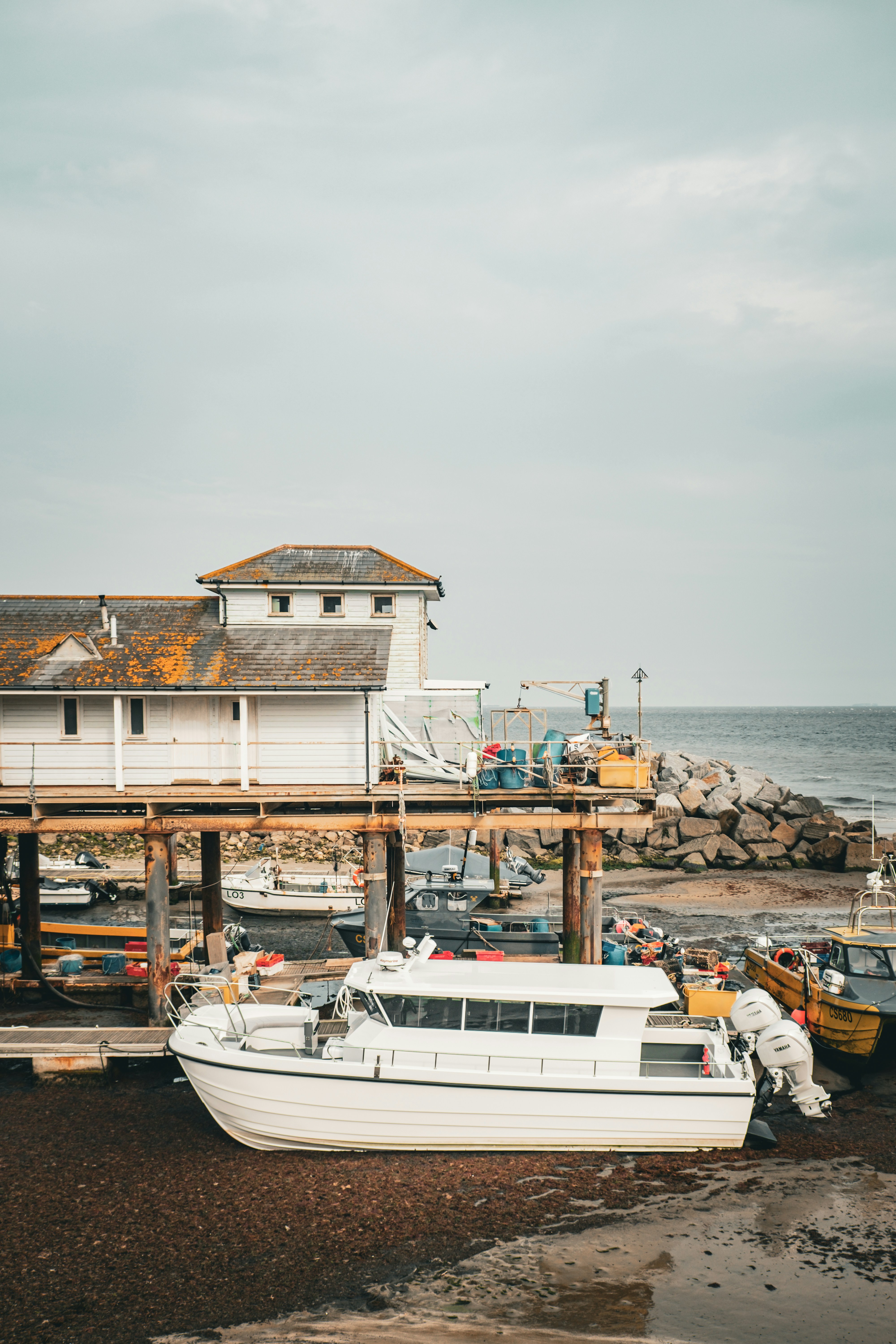 Harbor Glow: A White Boat Nestled Beneath a Weathered Pier