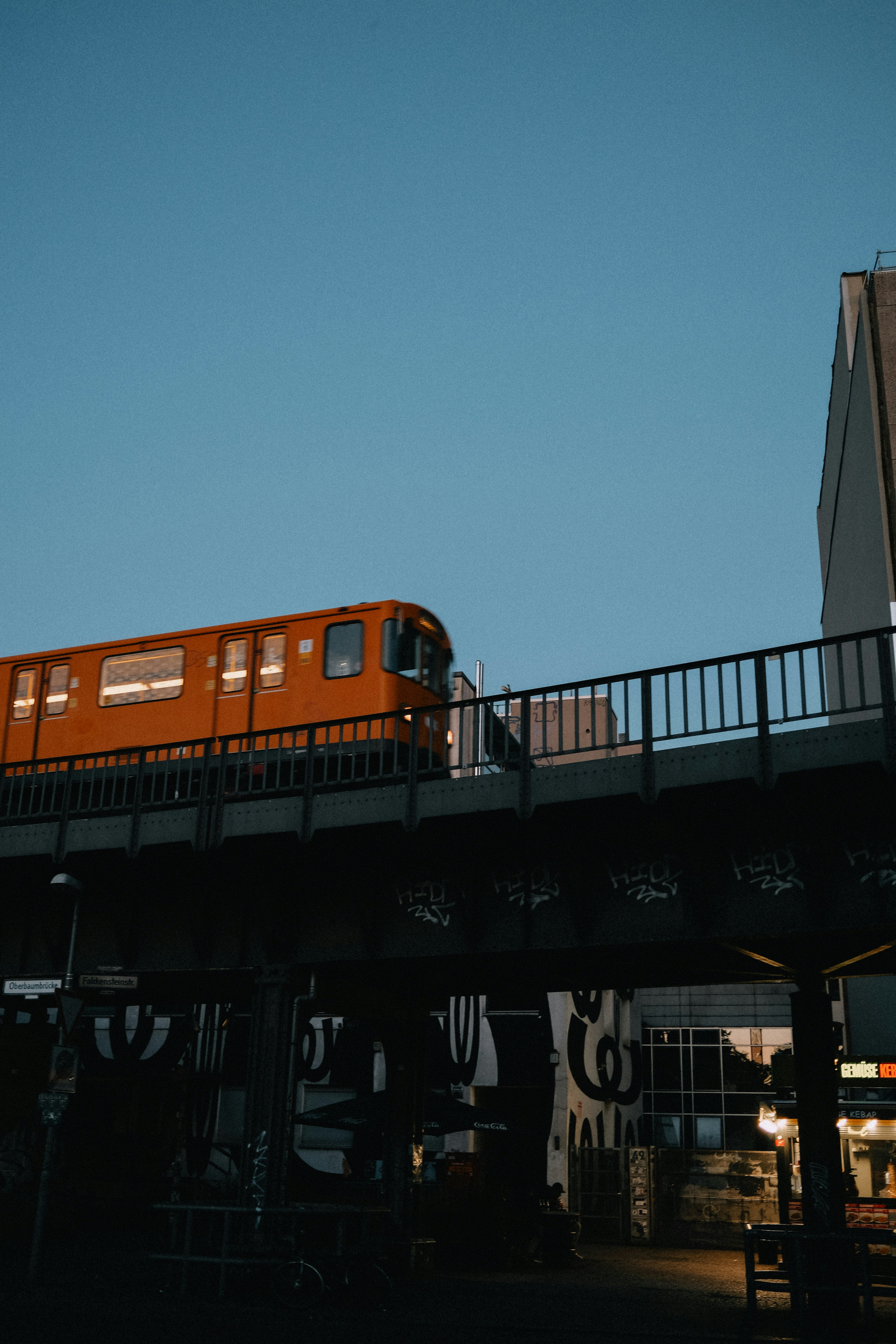 Orange Transit on an Elevated Stage Over Graffiti Pillars