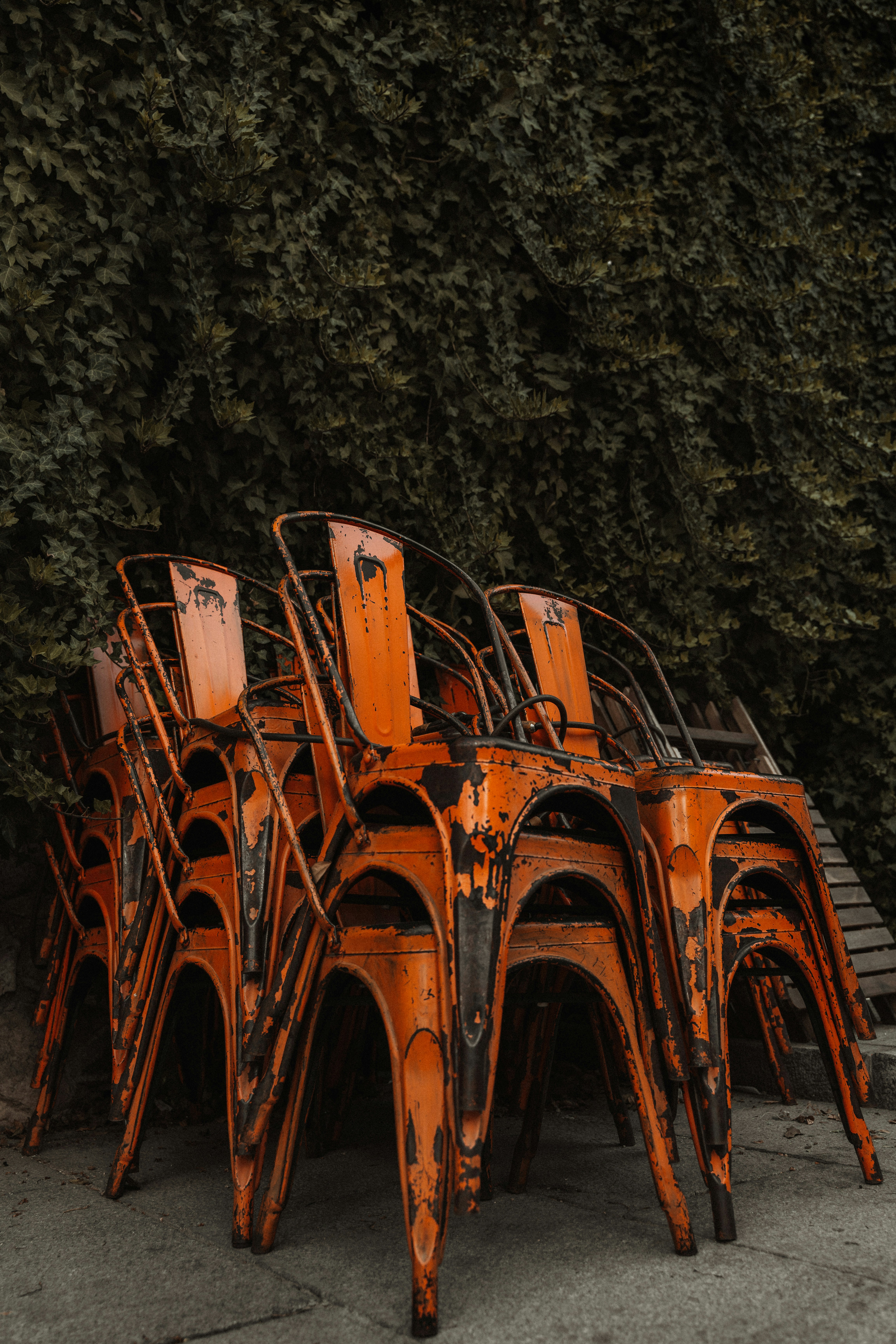 Rust and Shadow: A Quiet Stack of Orange Chairs