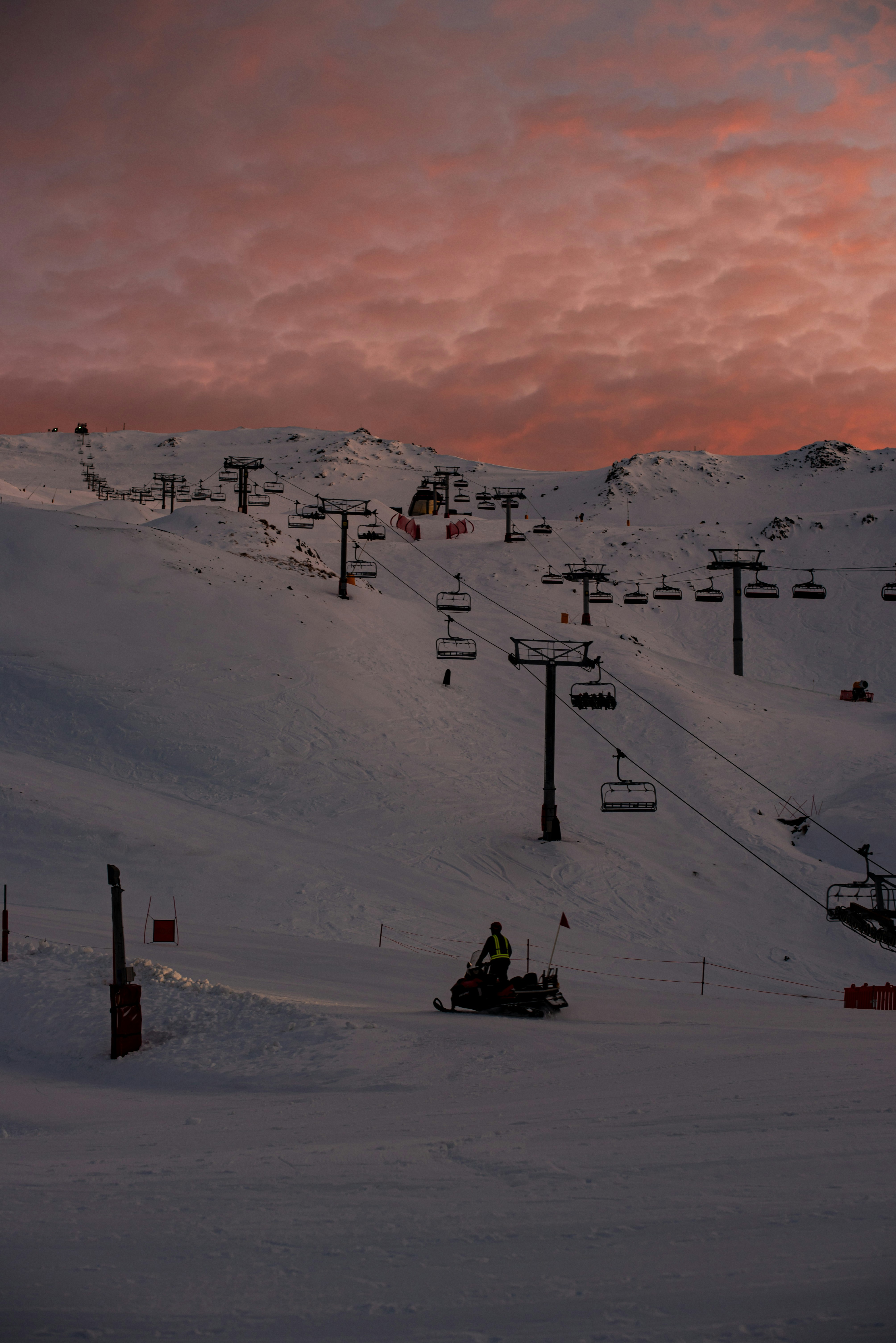 A snow covered ski slope with a ski lift in the distance photo – Free ...