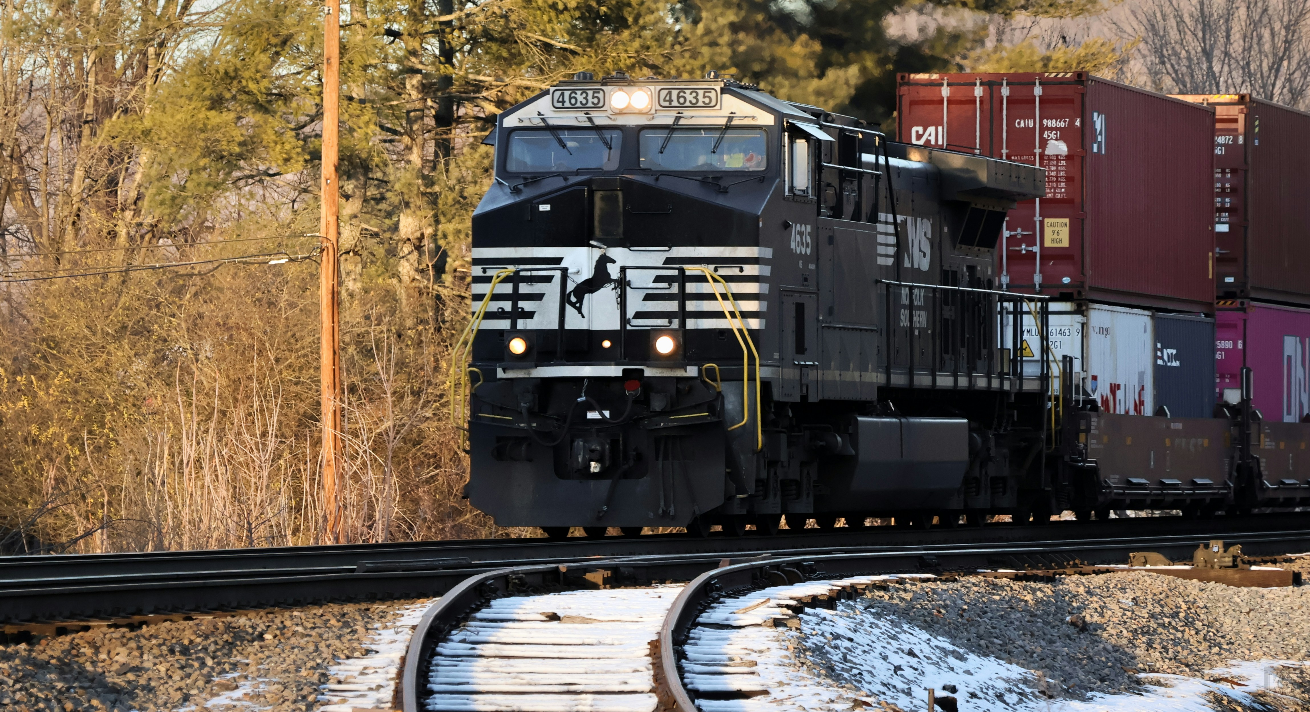 A train traveling down train tracks next to a forest photo – Free Rail ...