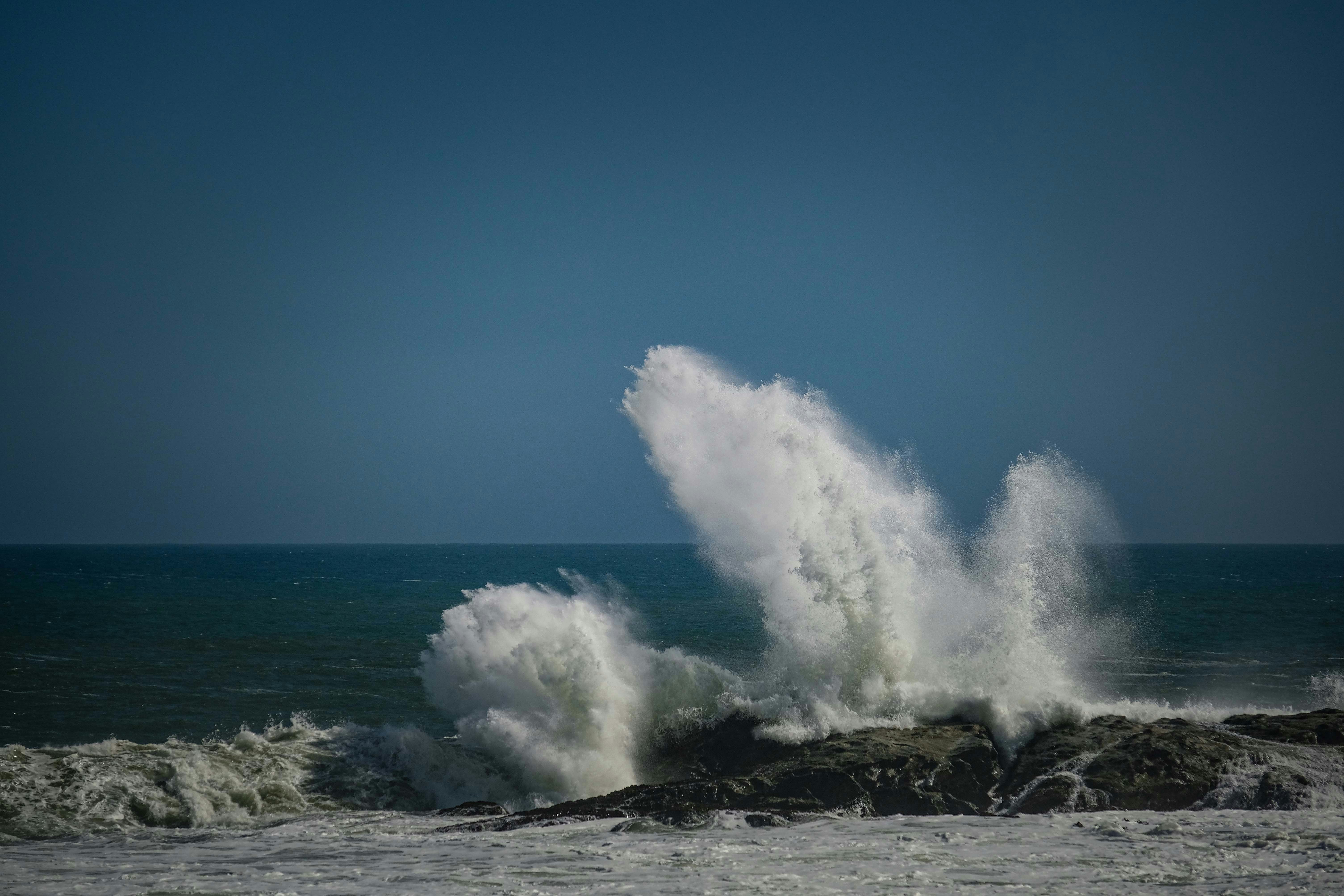 A large wave crashes into the shore of the ocean photo – Free Nature ...