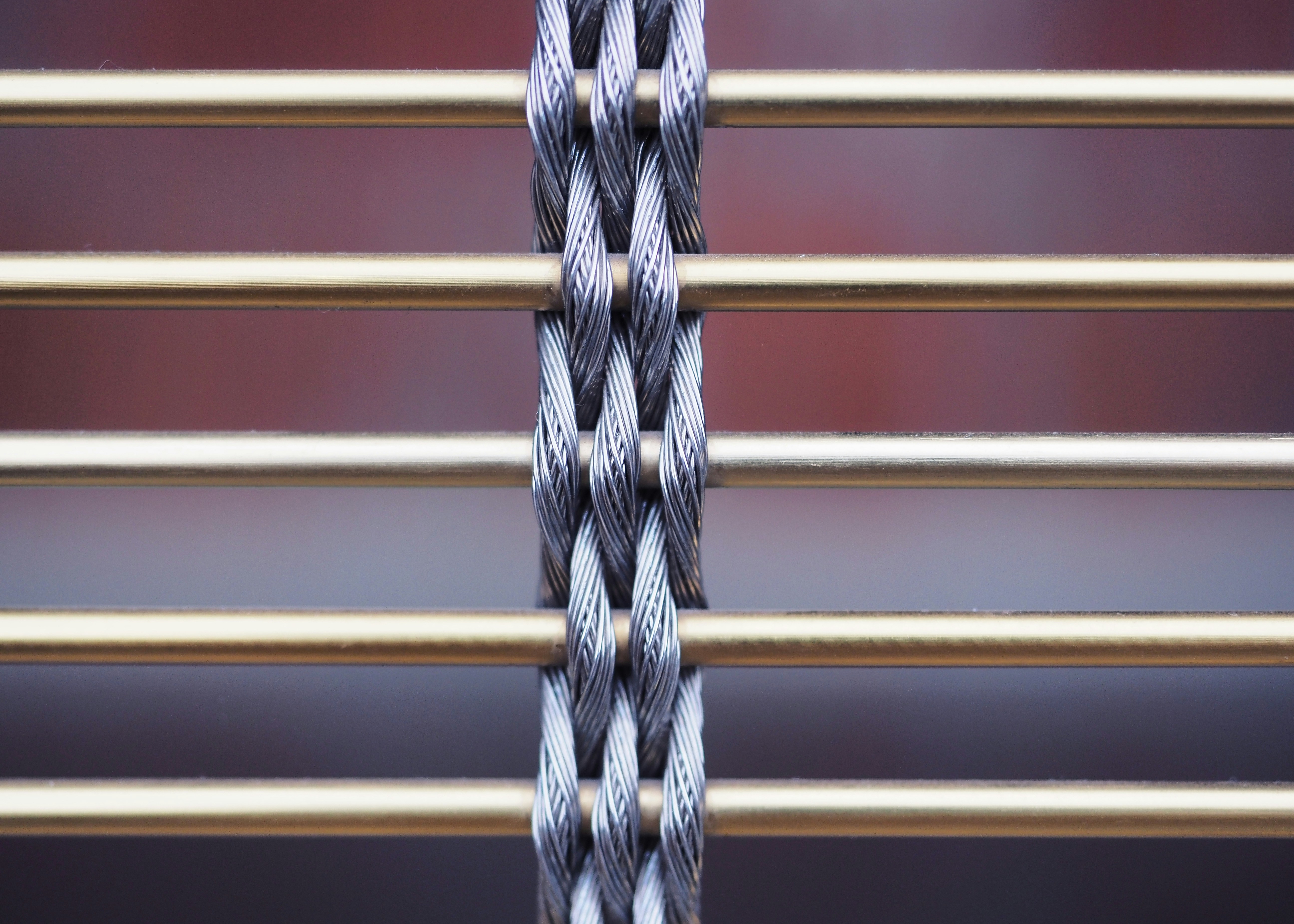 Close-up of intricately braided cables interspersed with metallic rods, showcasing a blend of industrial design and craftsmanship.