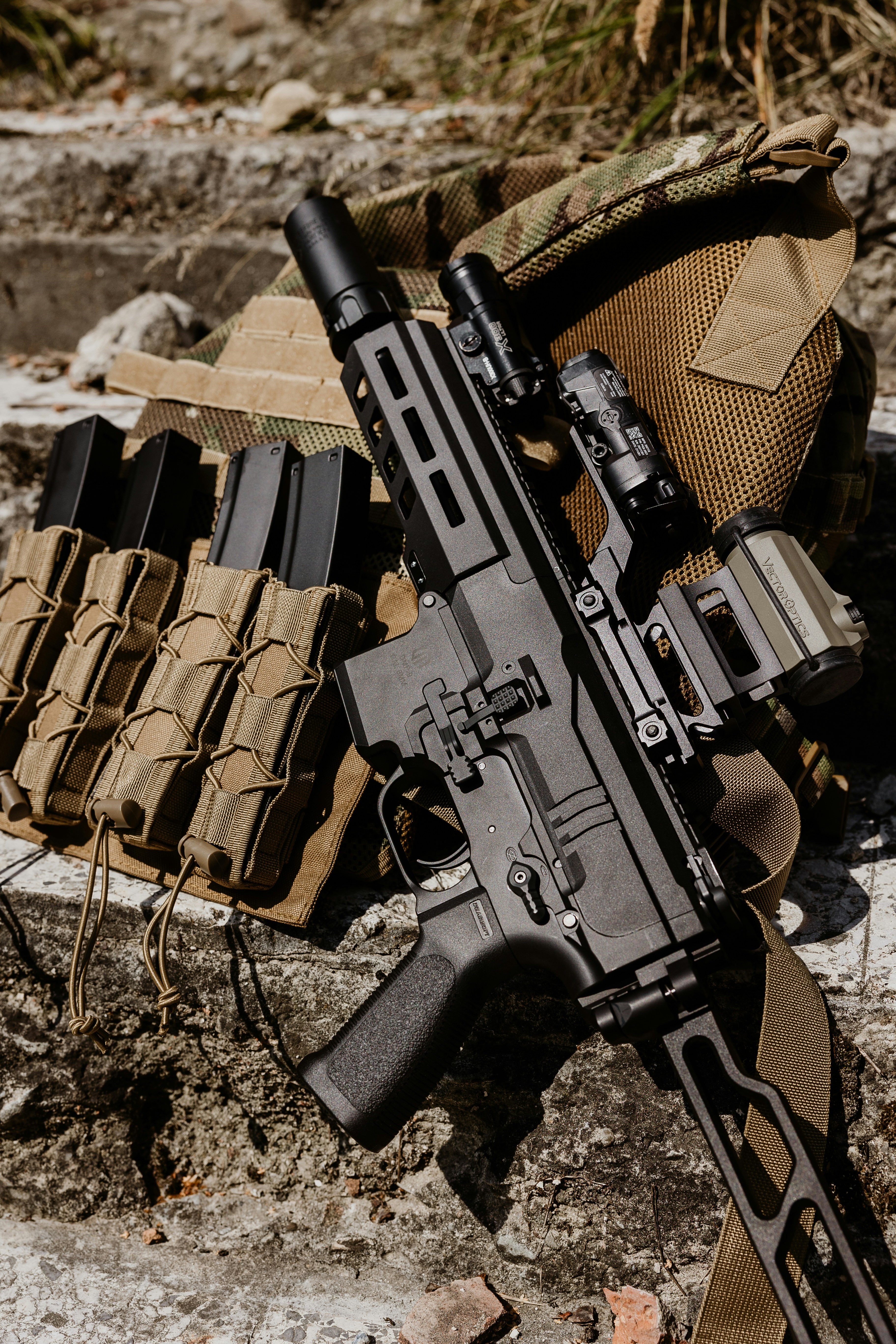 A rifle laying on the ground next to a pile of magazines photo – Free ...