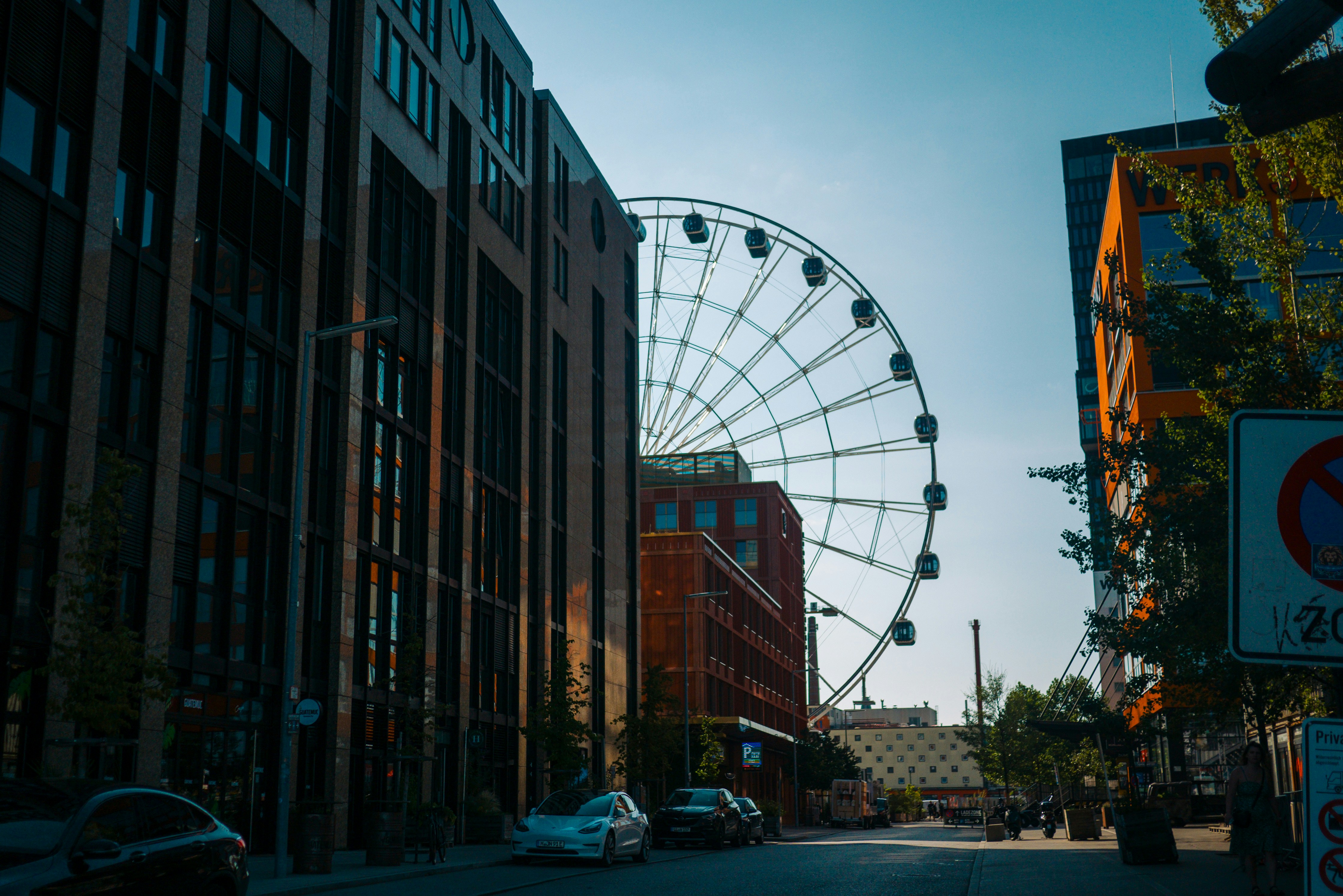 Ferris Wheel Over the City Street: A Distant Circle Framing Modern Architecture