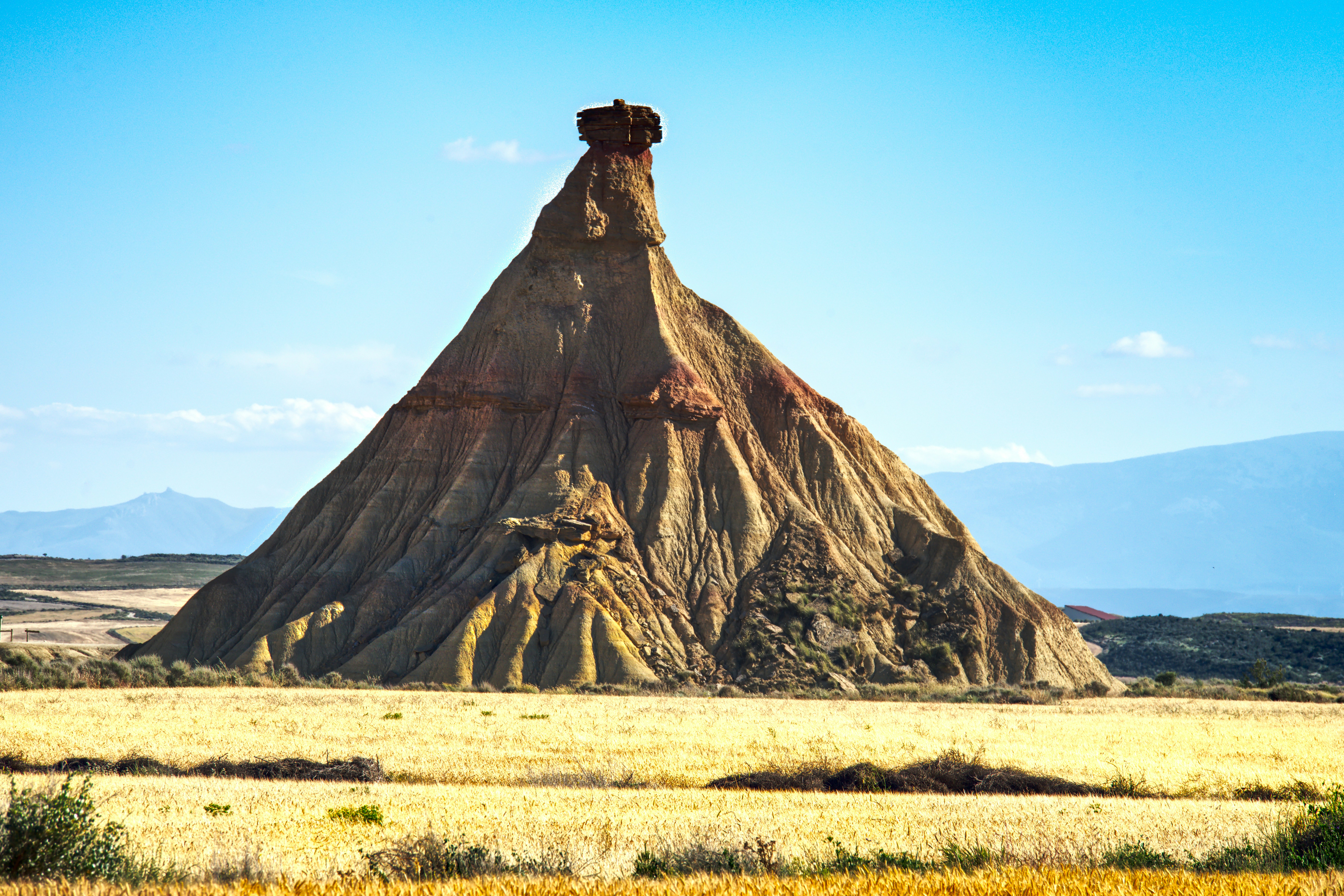 A large rock formation in the middle of a field photo – Free Bardenas ...
