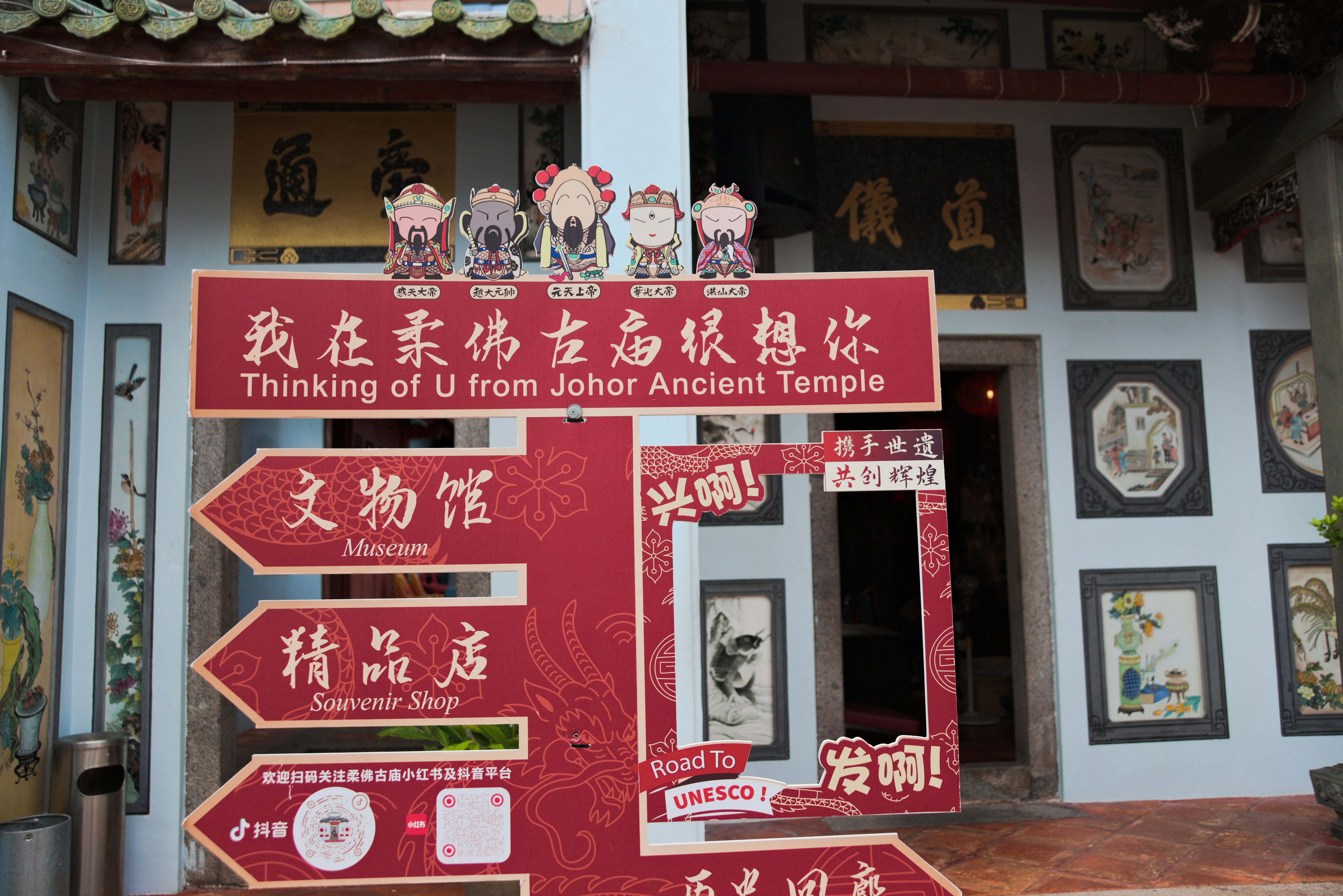 Red Signpost of a Johor Ancient Temple, Framed by Heritage Walls and Cat Ornaments