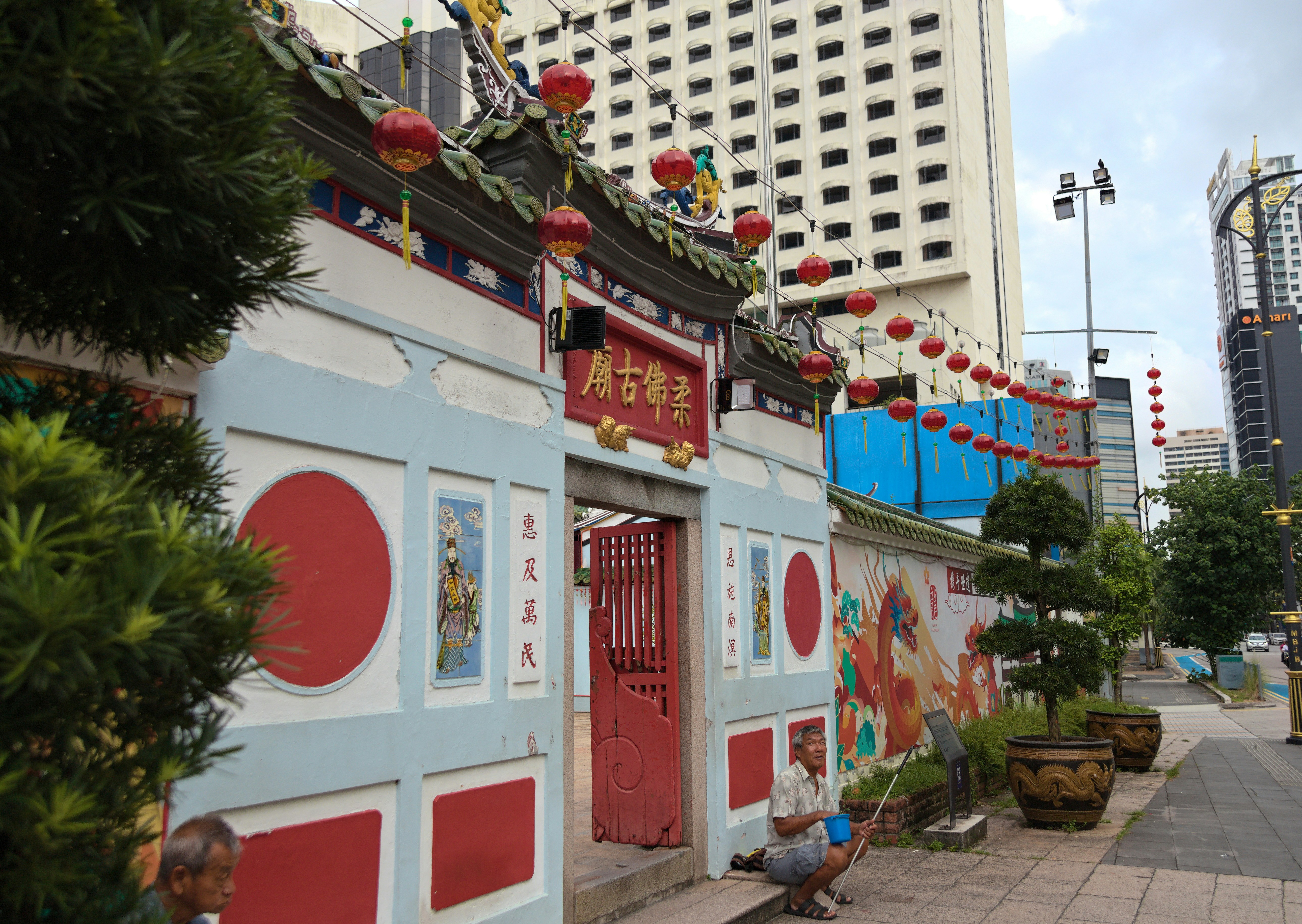 Red Gate under Lantern Arch: Temple Wall Framed by a Modern Skyline