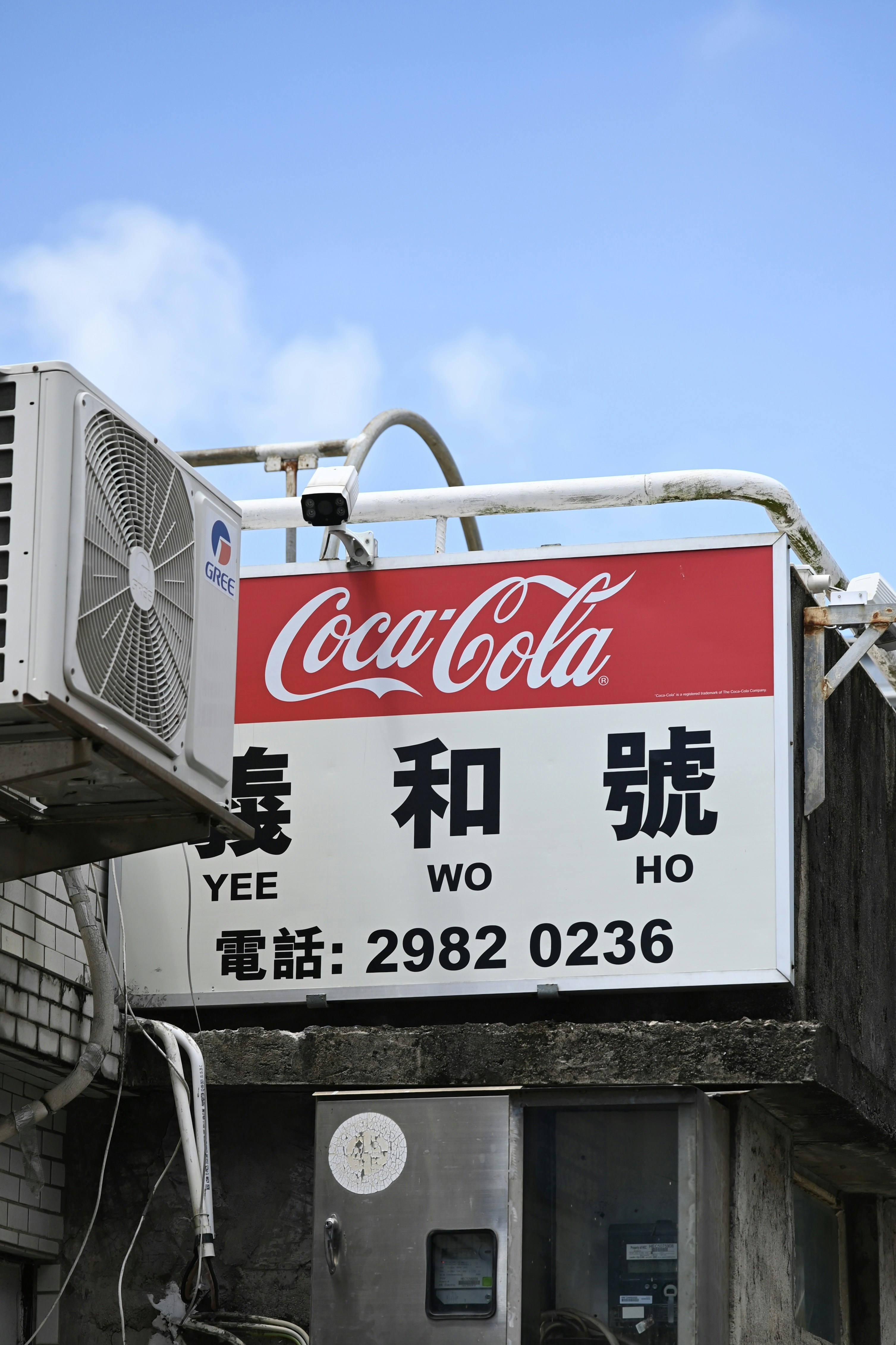 A coca - cola sign hanging off the side of a building photo – Free Coca ...