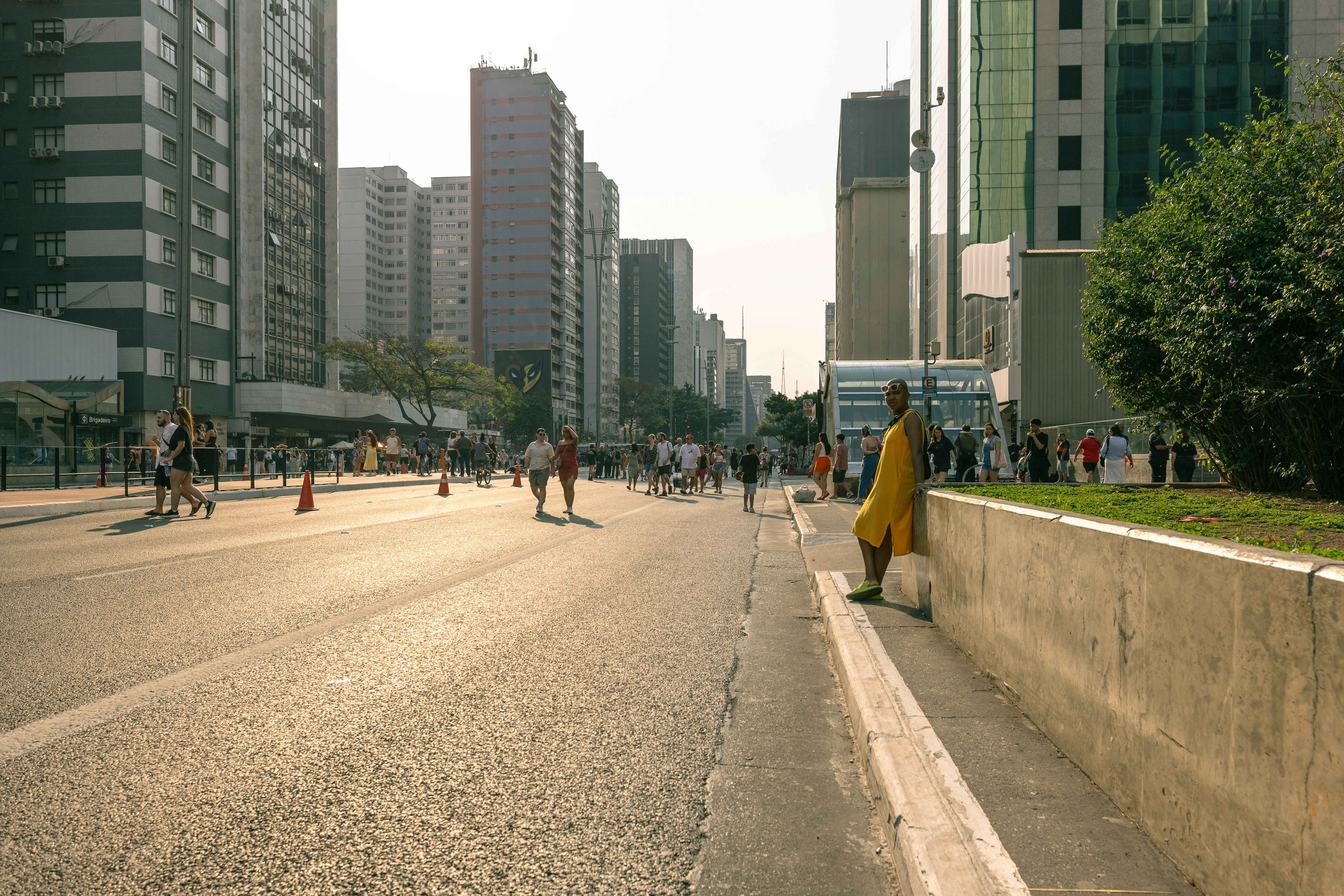 A woman in a yellow dress walking down a street photo – Free Brazil ...