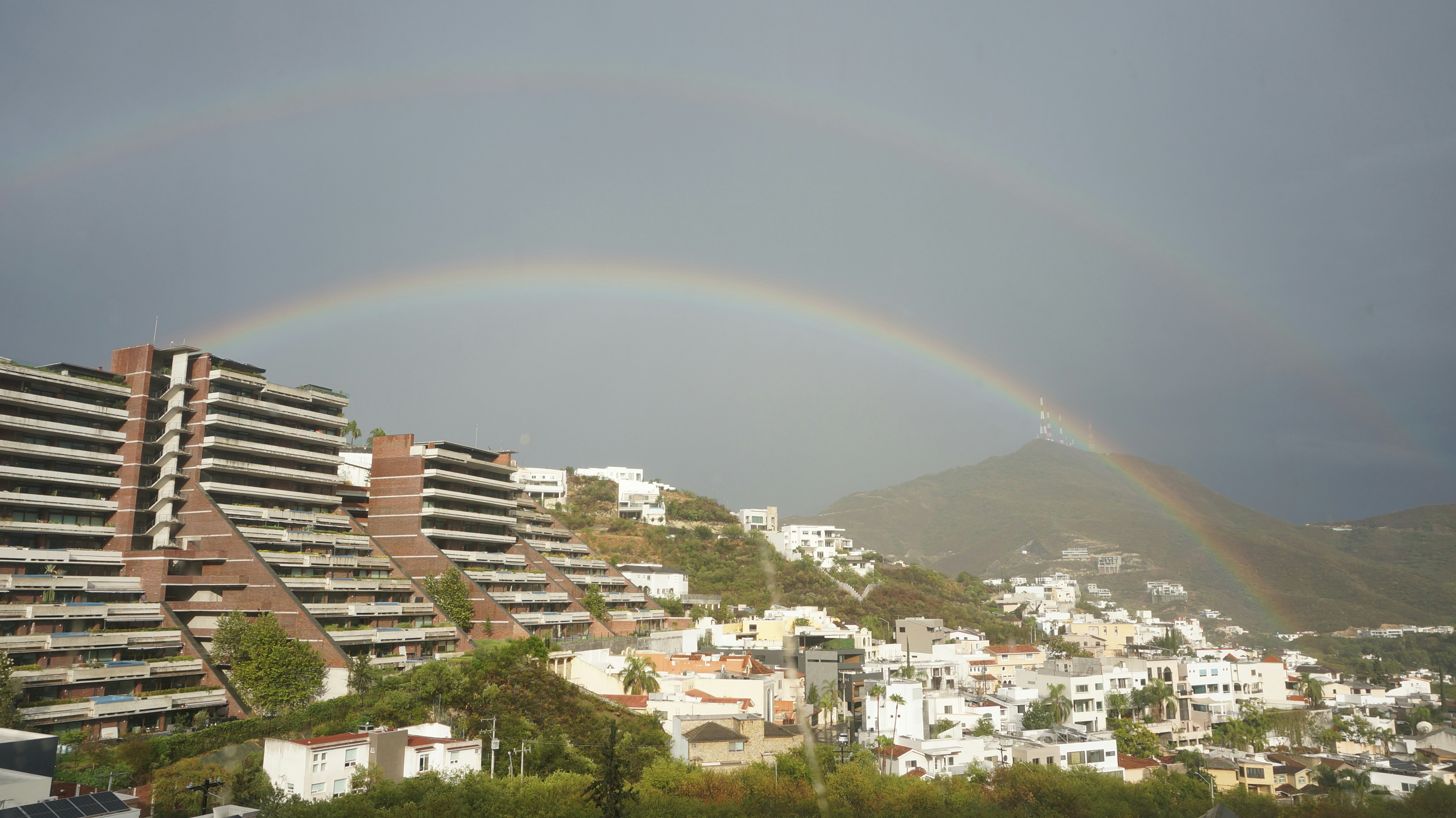 Double Rainbow Over a Terraced hillside Cityscape