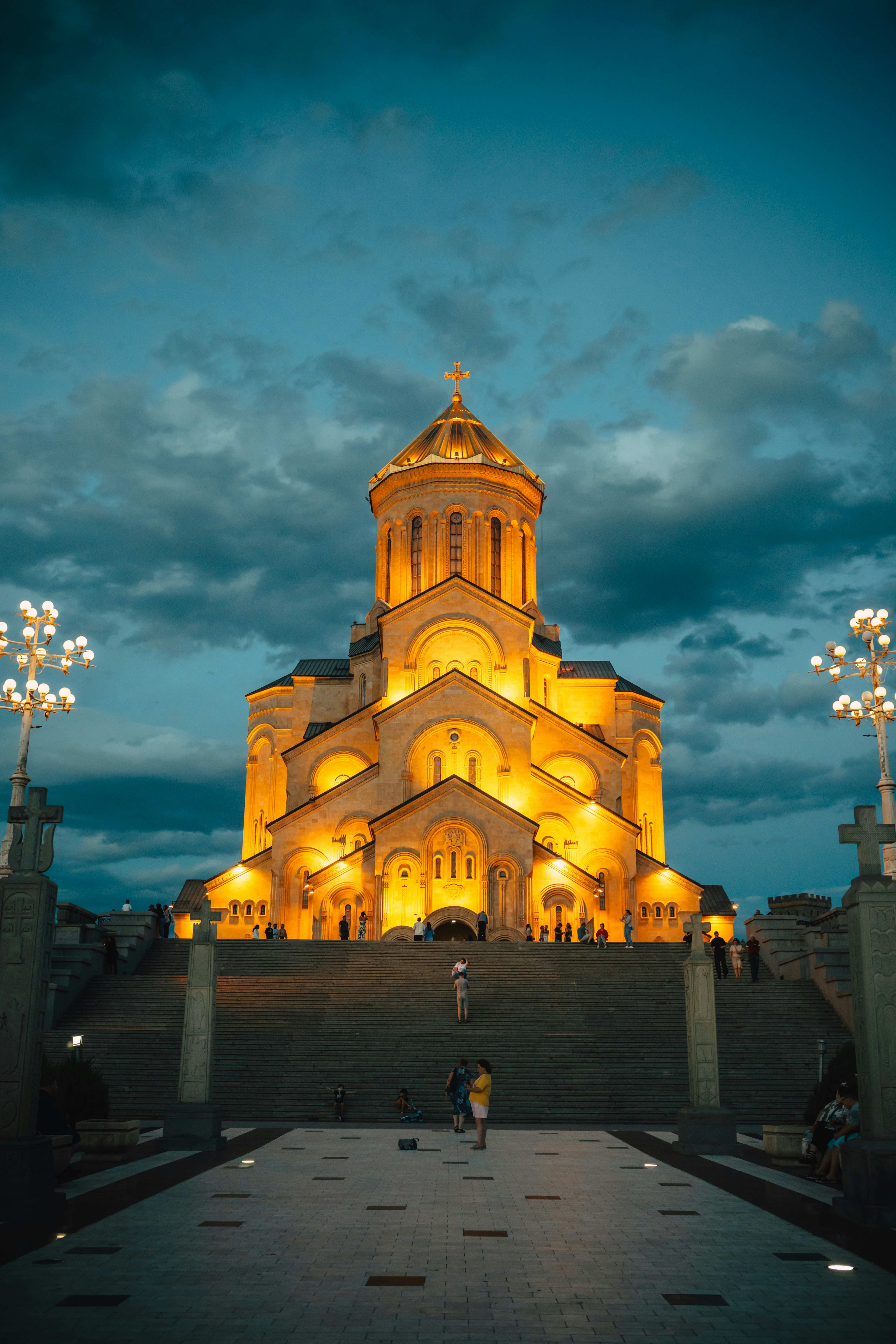 A church lit up at night with people standing outside photo – Free ...
