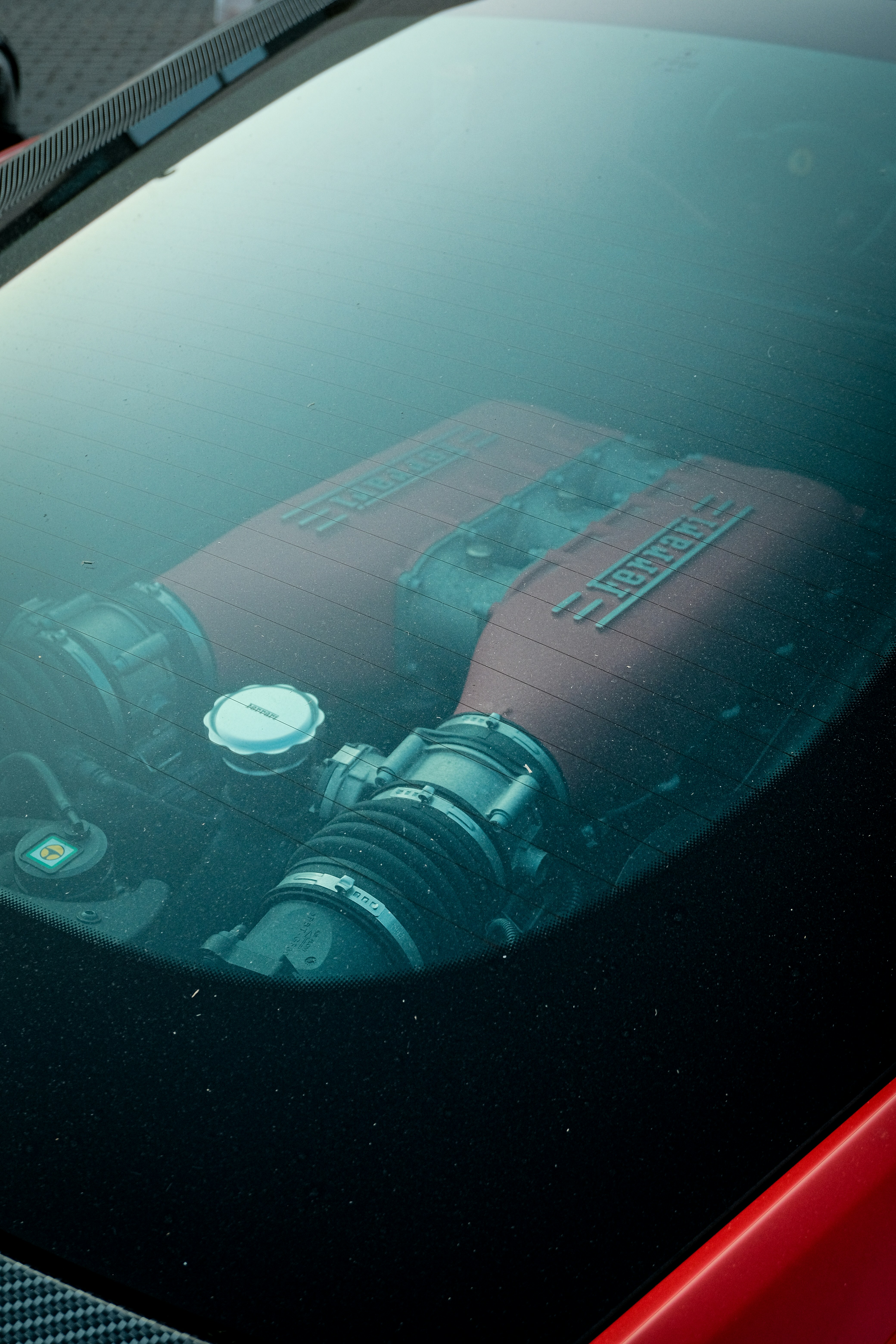 Teal Reflections Unveil a Ferrari V12 Beneath the Windshield