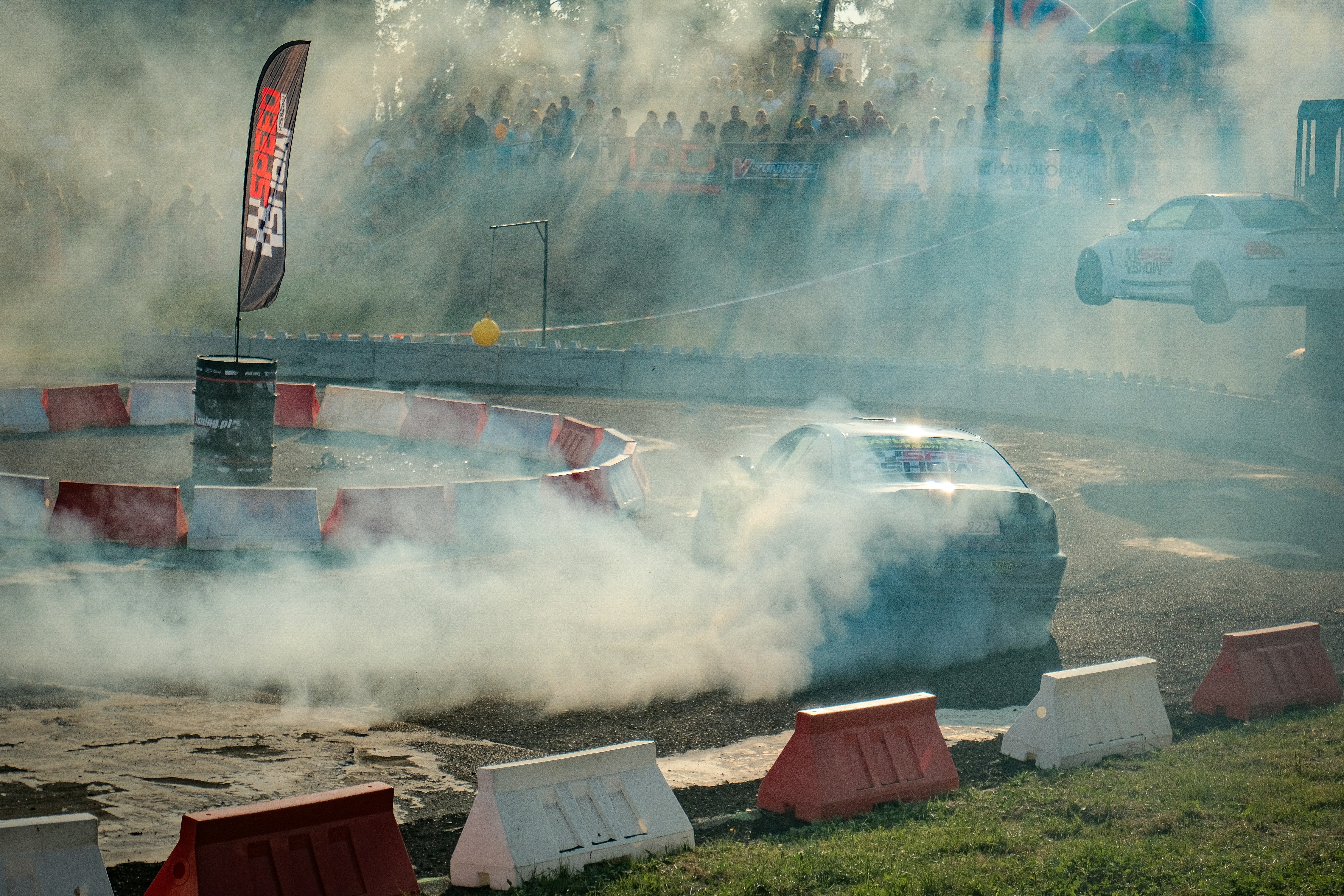Tire Smoke Tango: Drift Car Wedges Through Fog Between Barricades