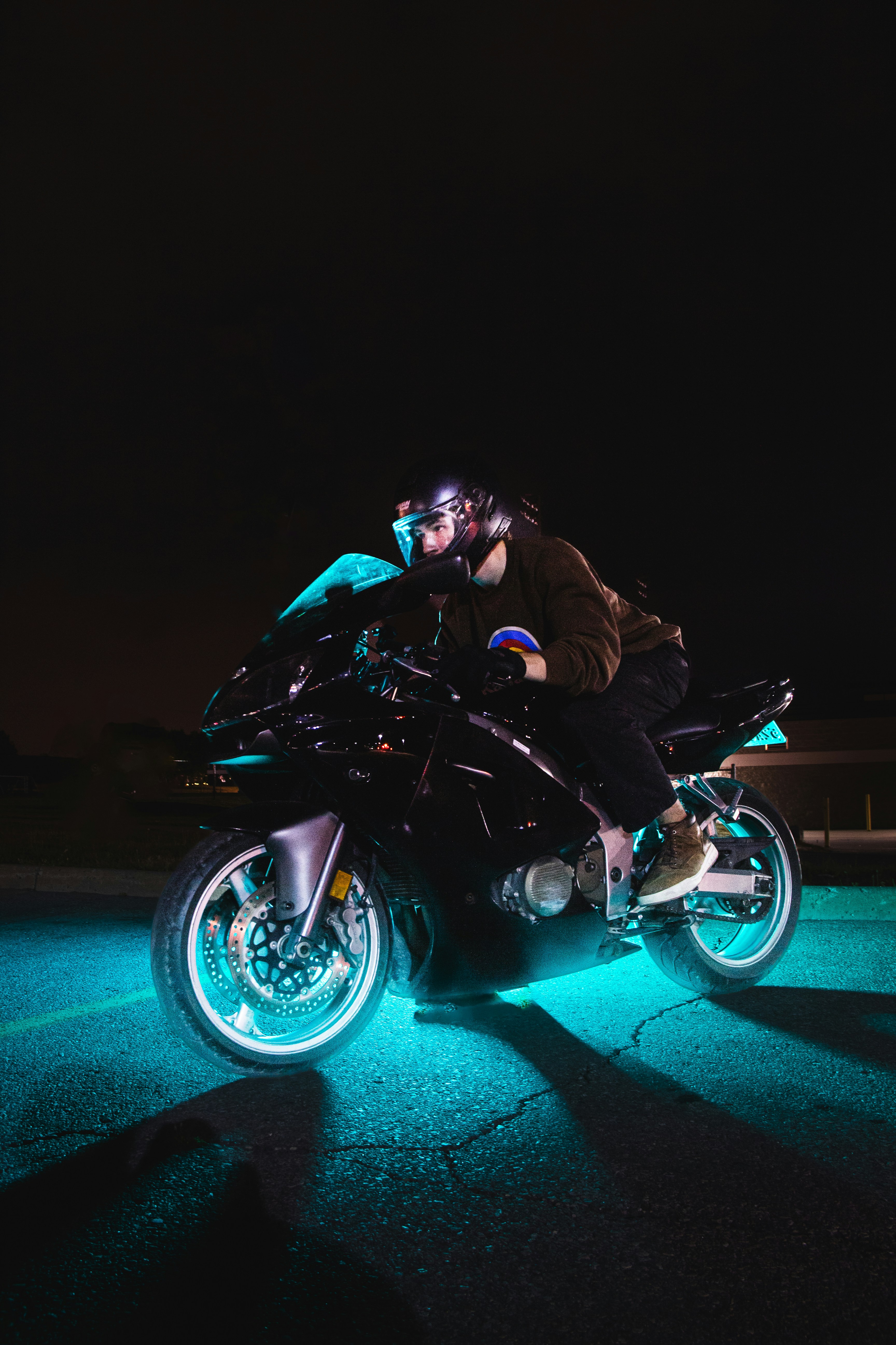 A man riding on the back of a motorcycle at night photo – Free ...