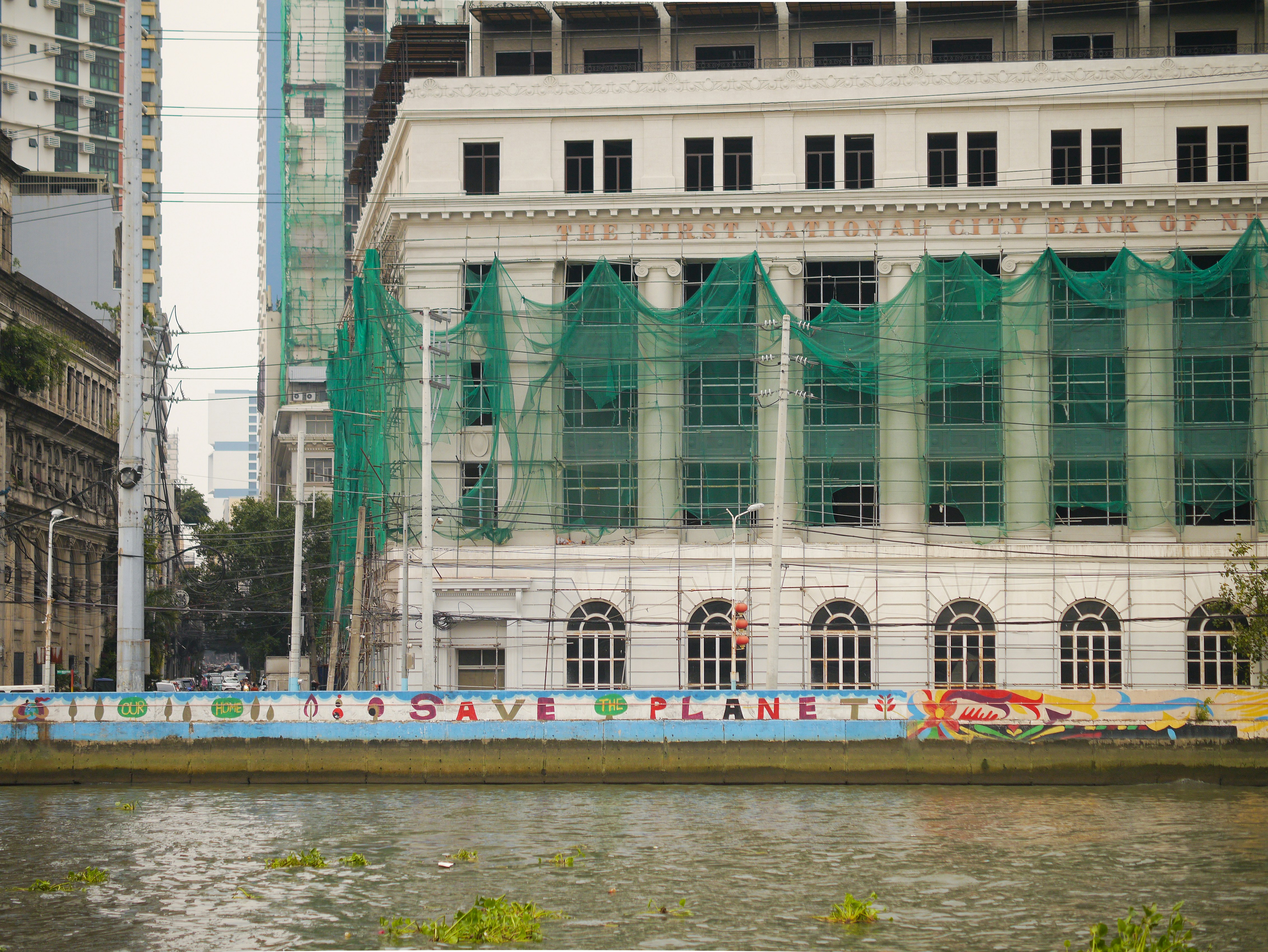 A large white building with green curtains on the side of it photo ...