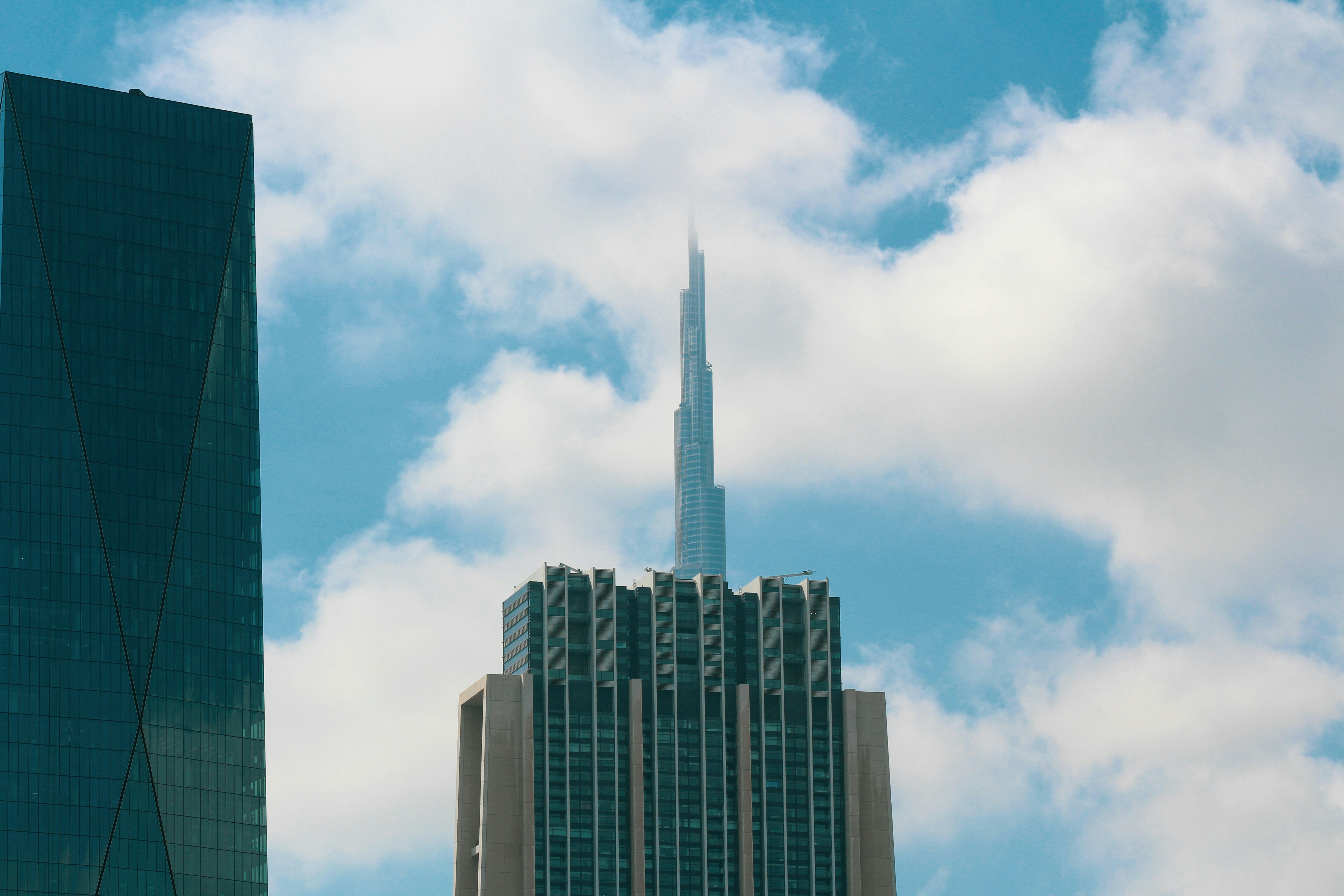 A tall building with a very tall spire in the background photo – Free ...