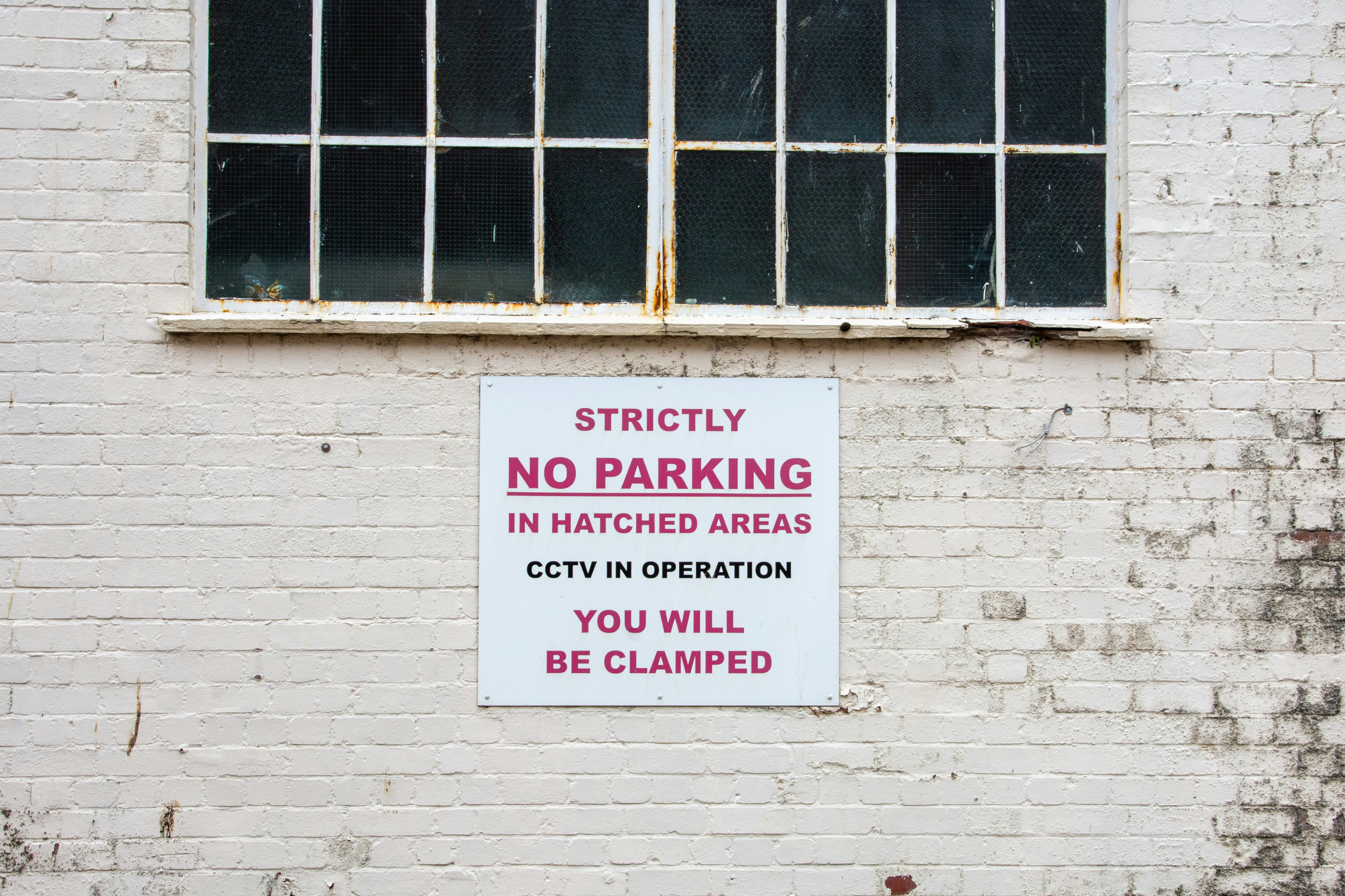 Secure Ward: A Weathered Sign Guarding an Old Brick Wall