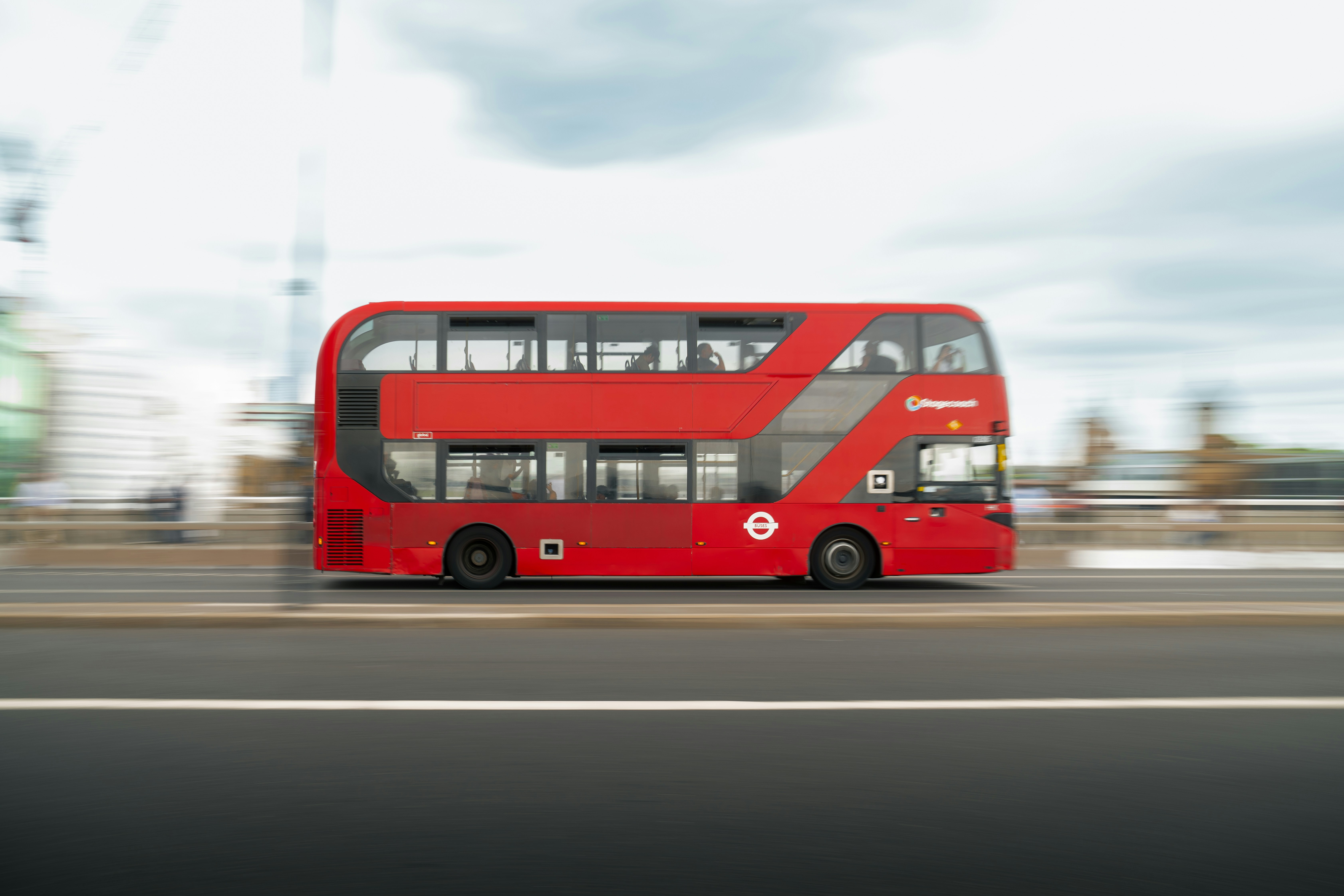 A red double decker bus driving down a street photo – Free London Image ...