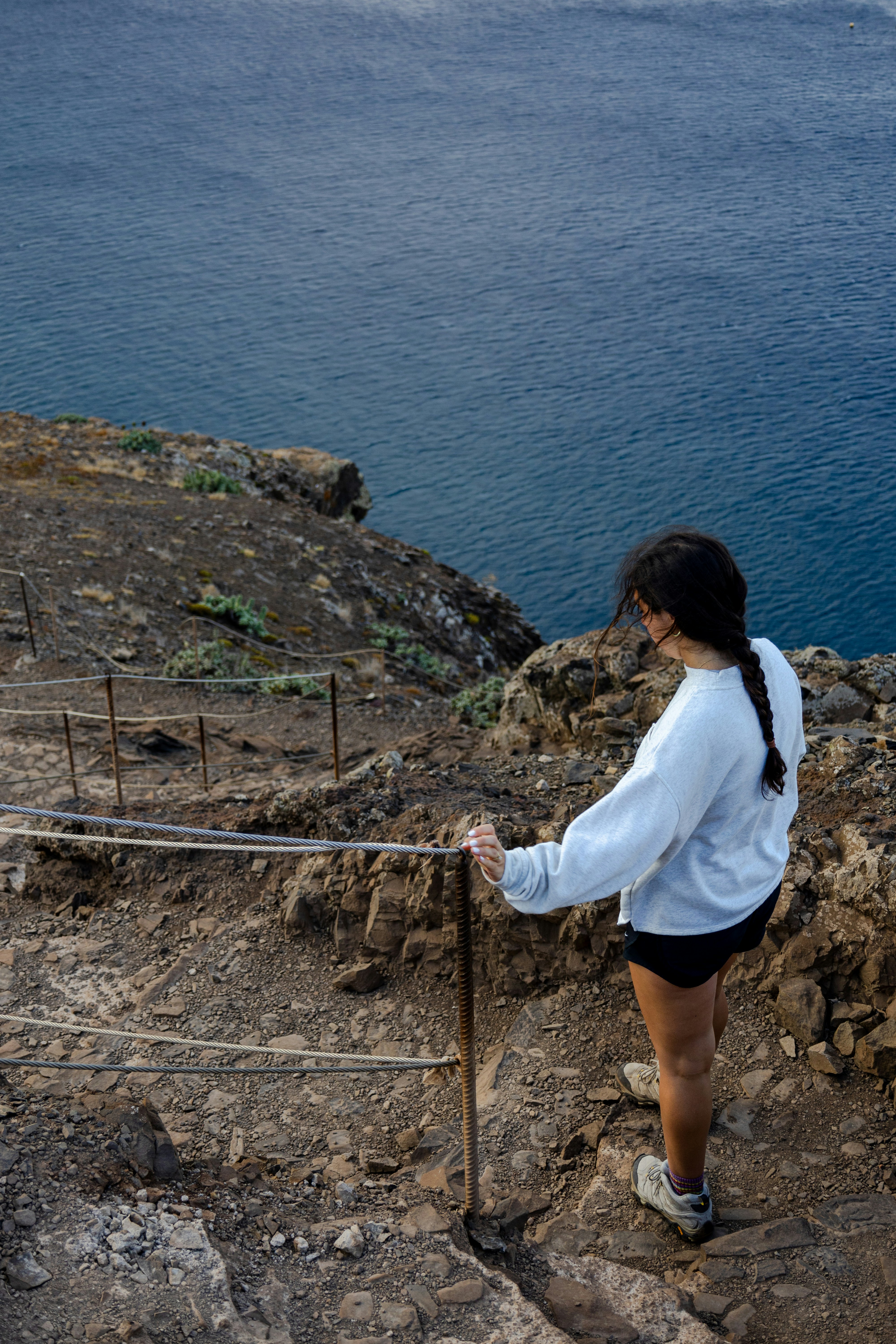 Toward the Blue Edge: a solitary hiker on a rocky cliff overlook