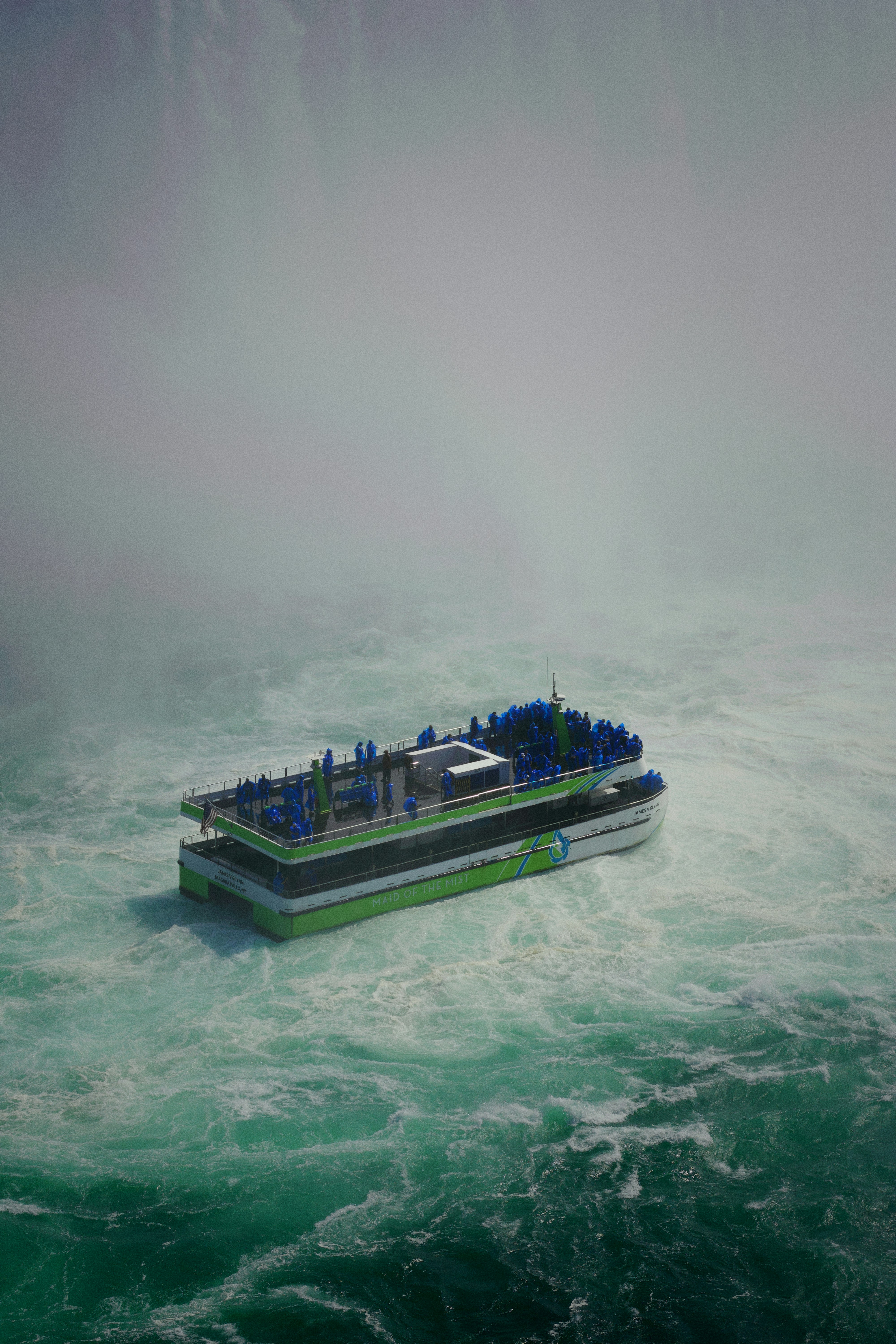 Blue-Caps in Emerald Mist: A Tour Boat Slices Through Dense Fog