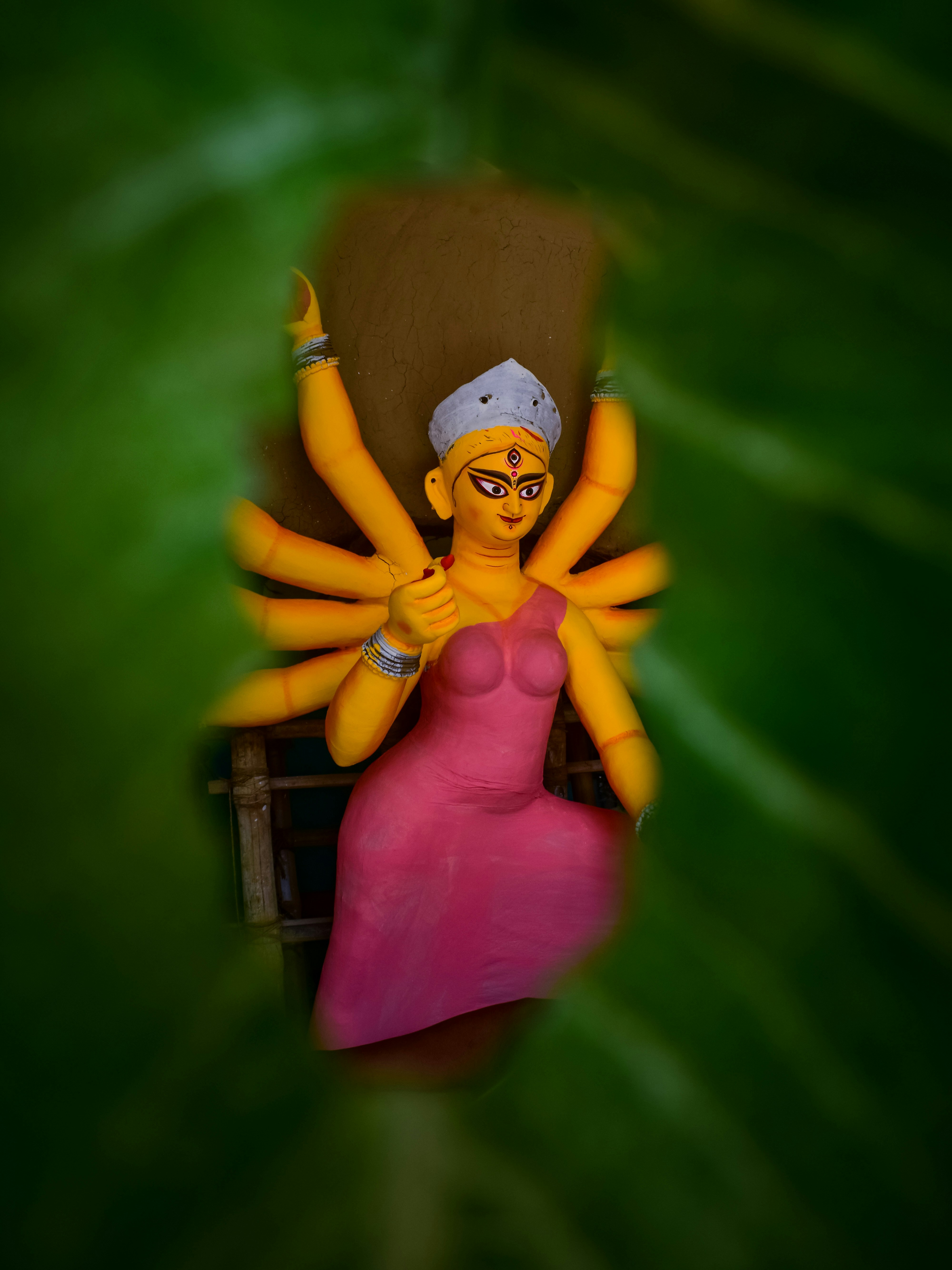 Six-armed Diva in a Pink Dress Peeking Through Green Veil