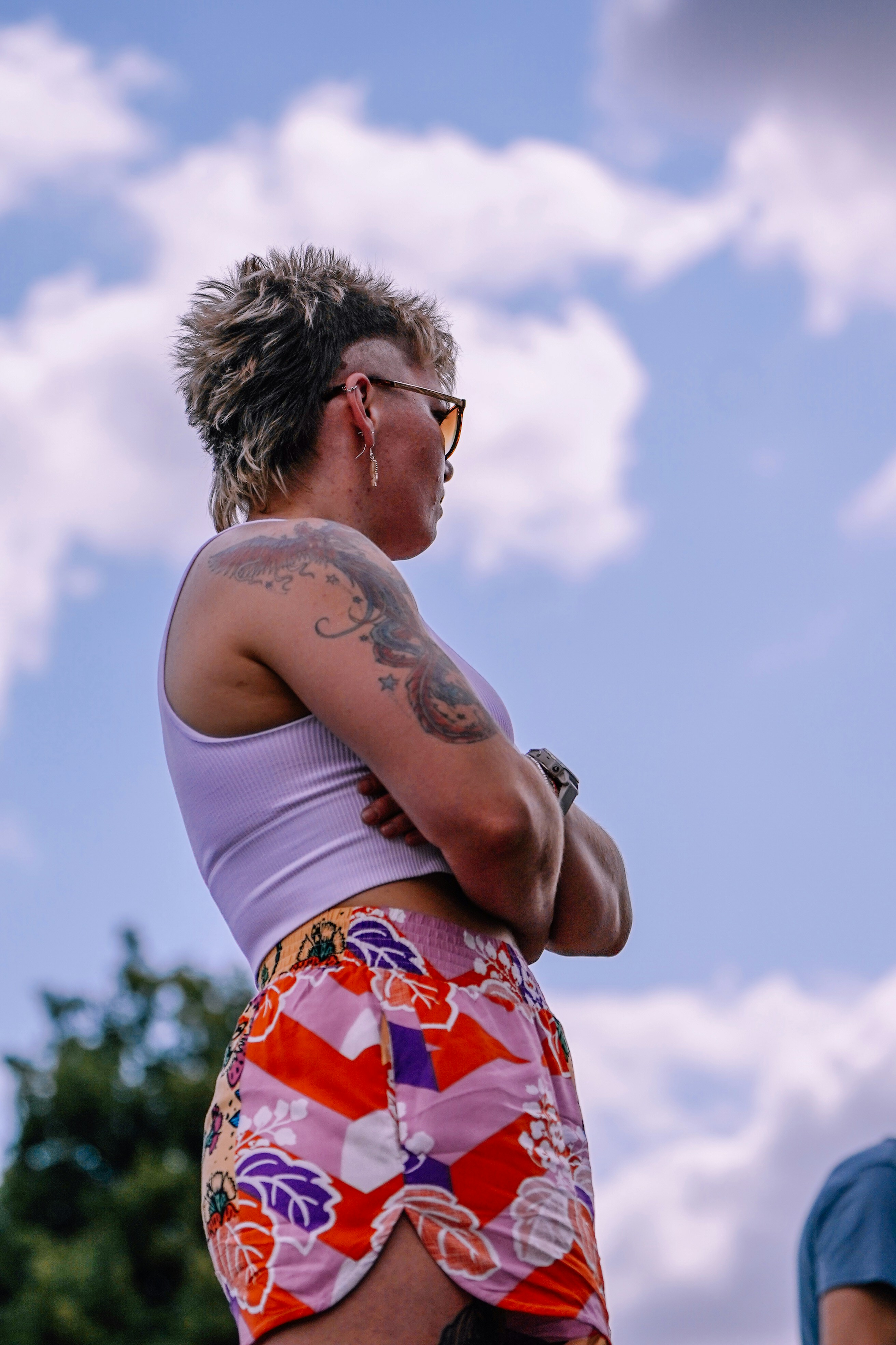 Bold Summer Portrait: Tattooed Attitude in Vibrant Floral Shorts