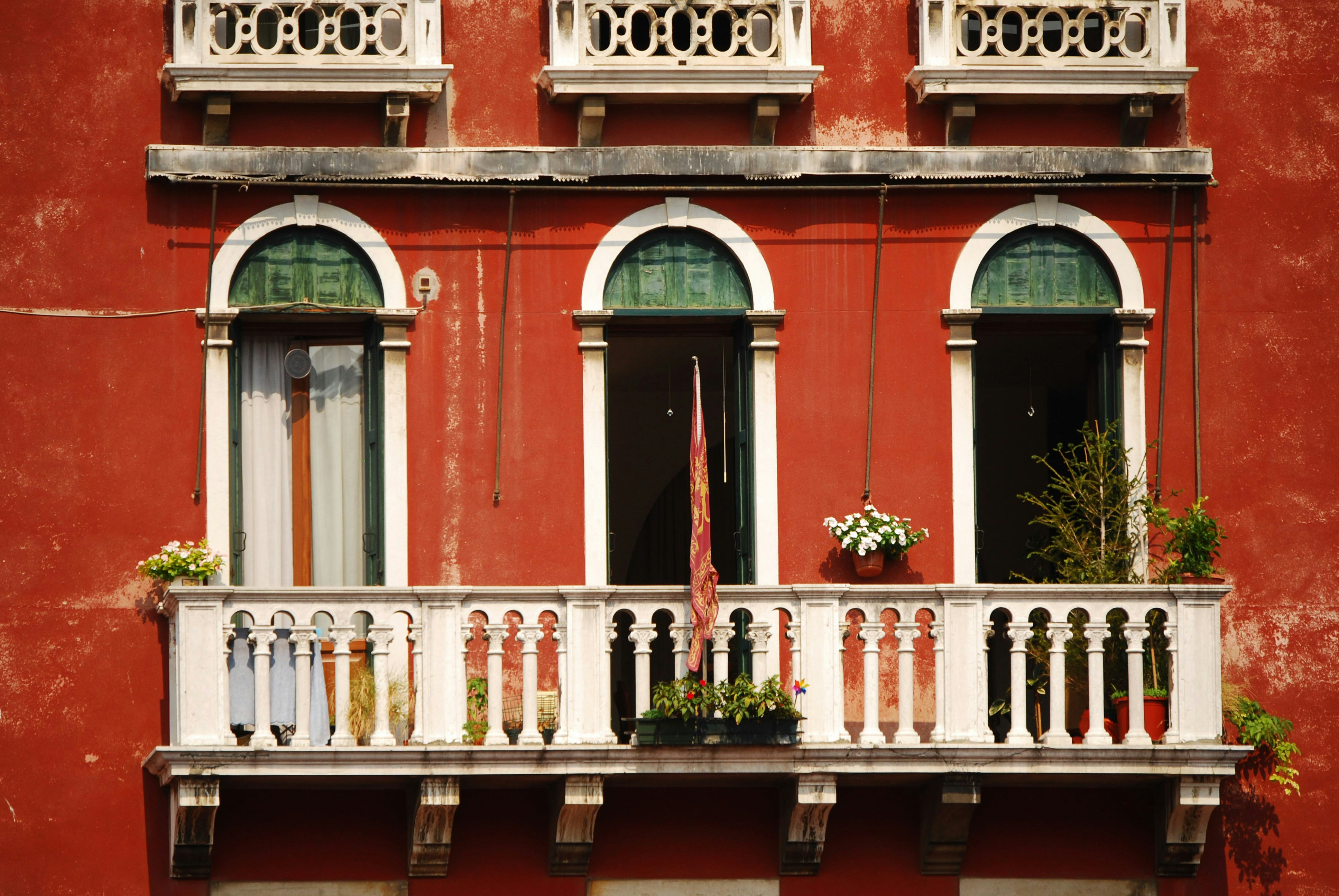 A red building with white balconies and windows photo – Free Venezia ...